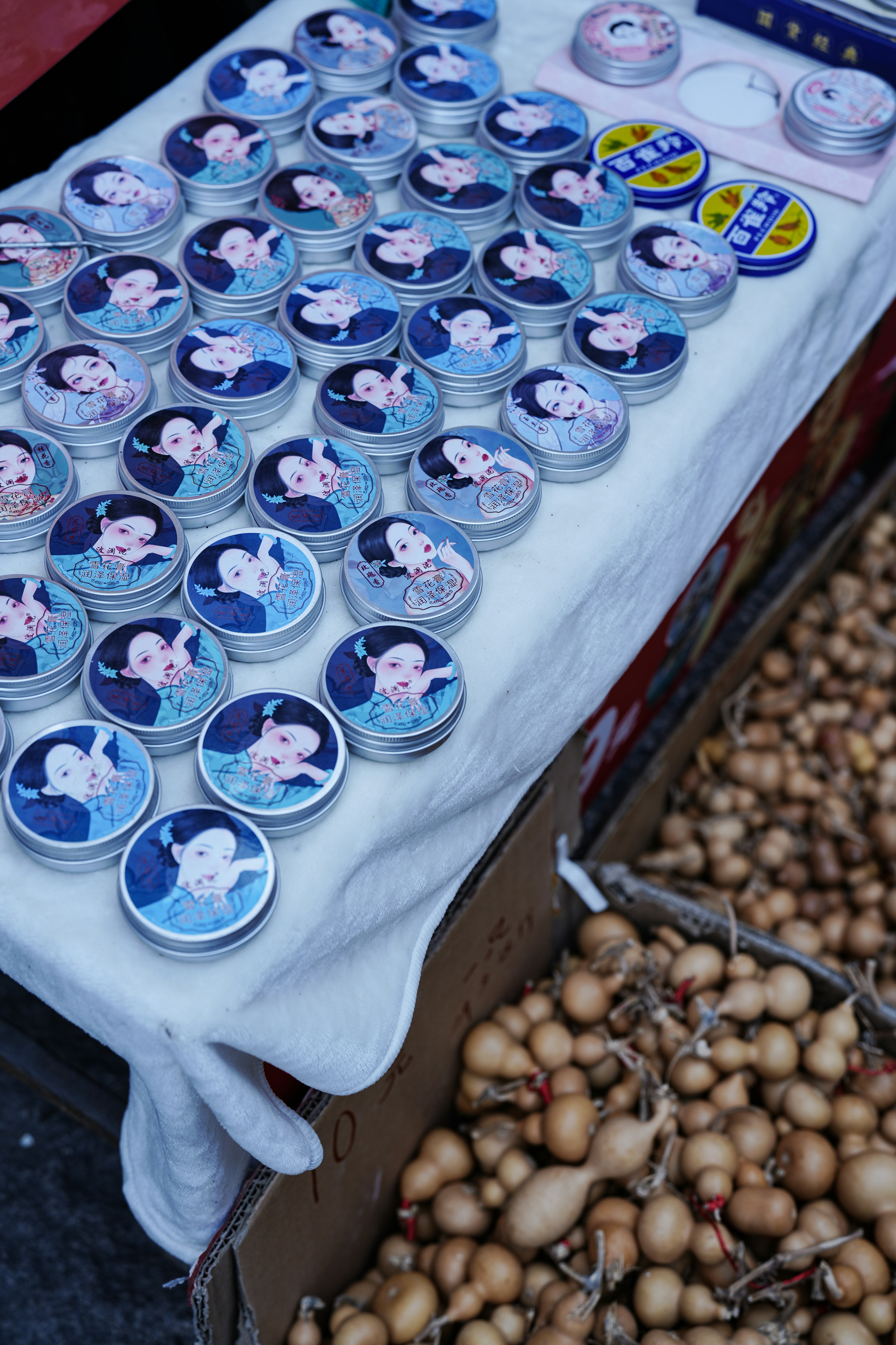 Round Tin Portraits Spread Across a Market Table