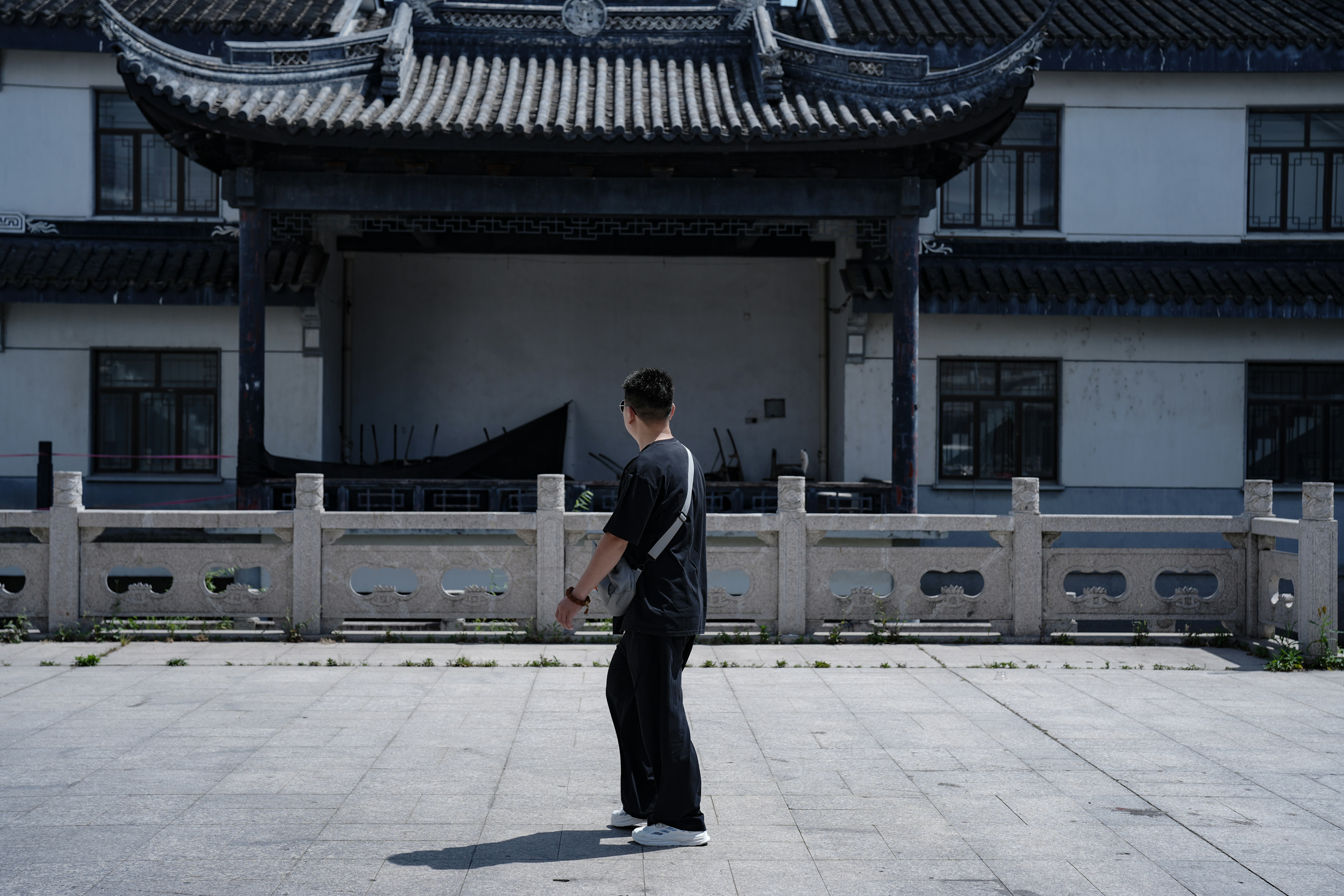 Solitary figure in a timeless courtyard under traditional eaves