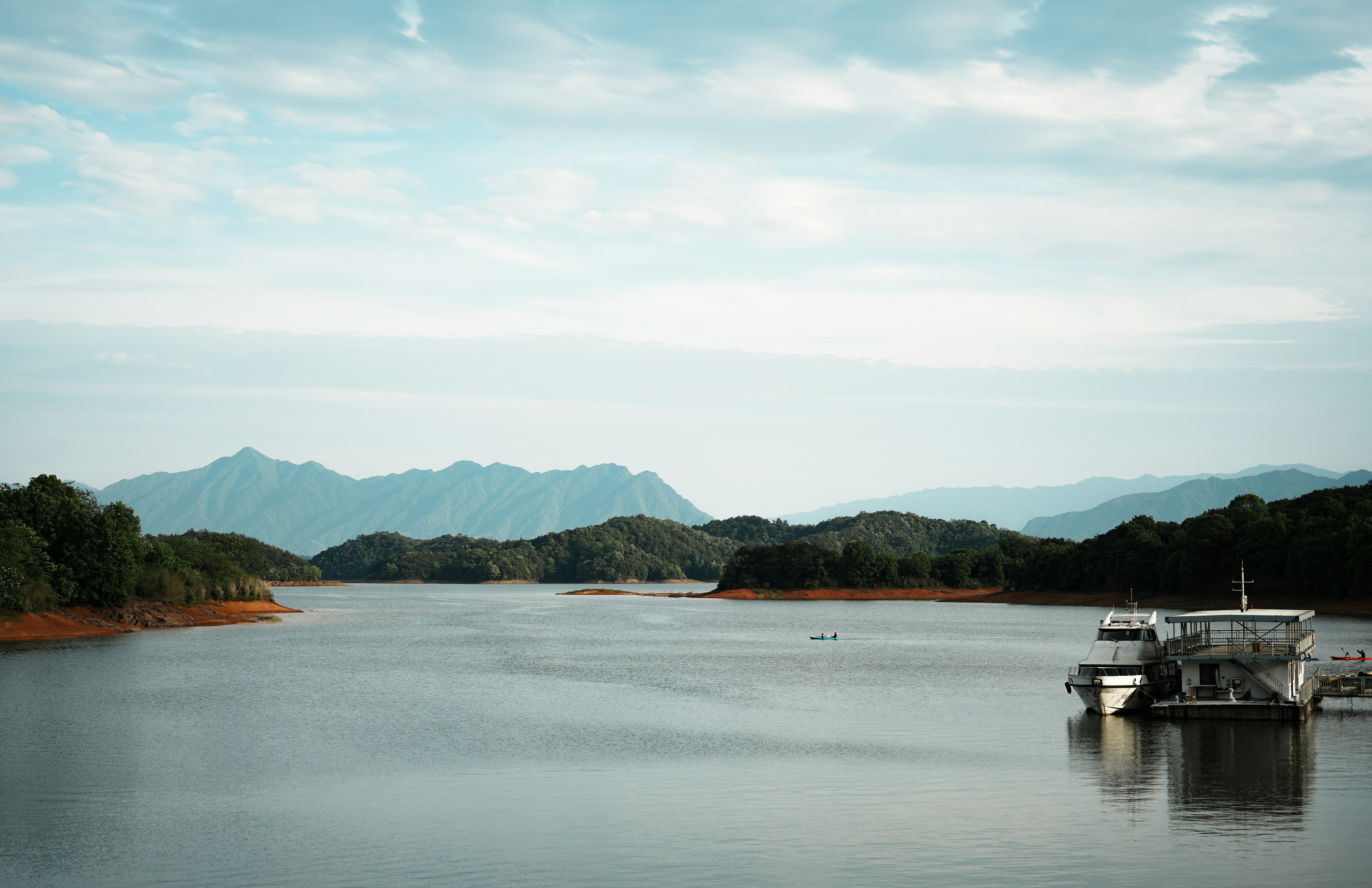 River At Dusk: A Quiet Vessel Neighbors the Distant Hills