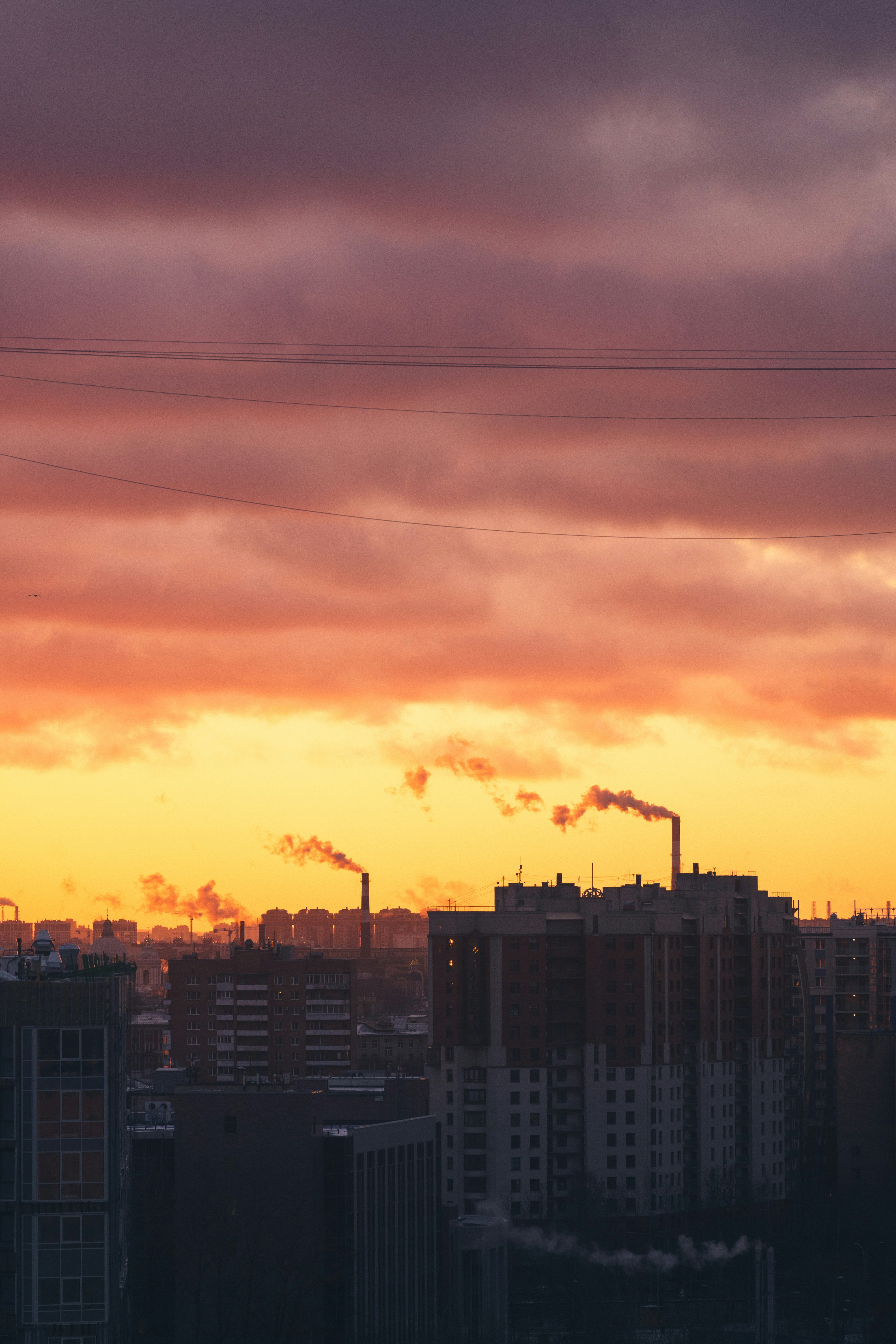 Industrial silhouettes at sunset: smoke and power against a violet sky