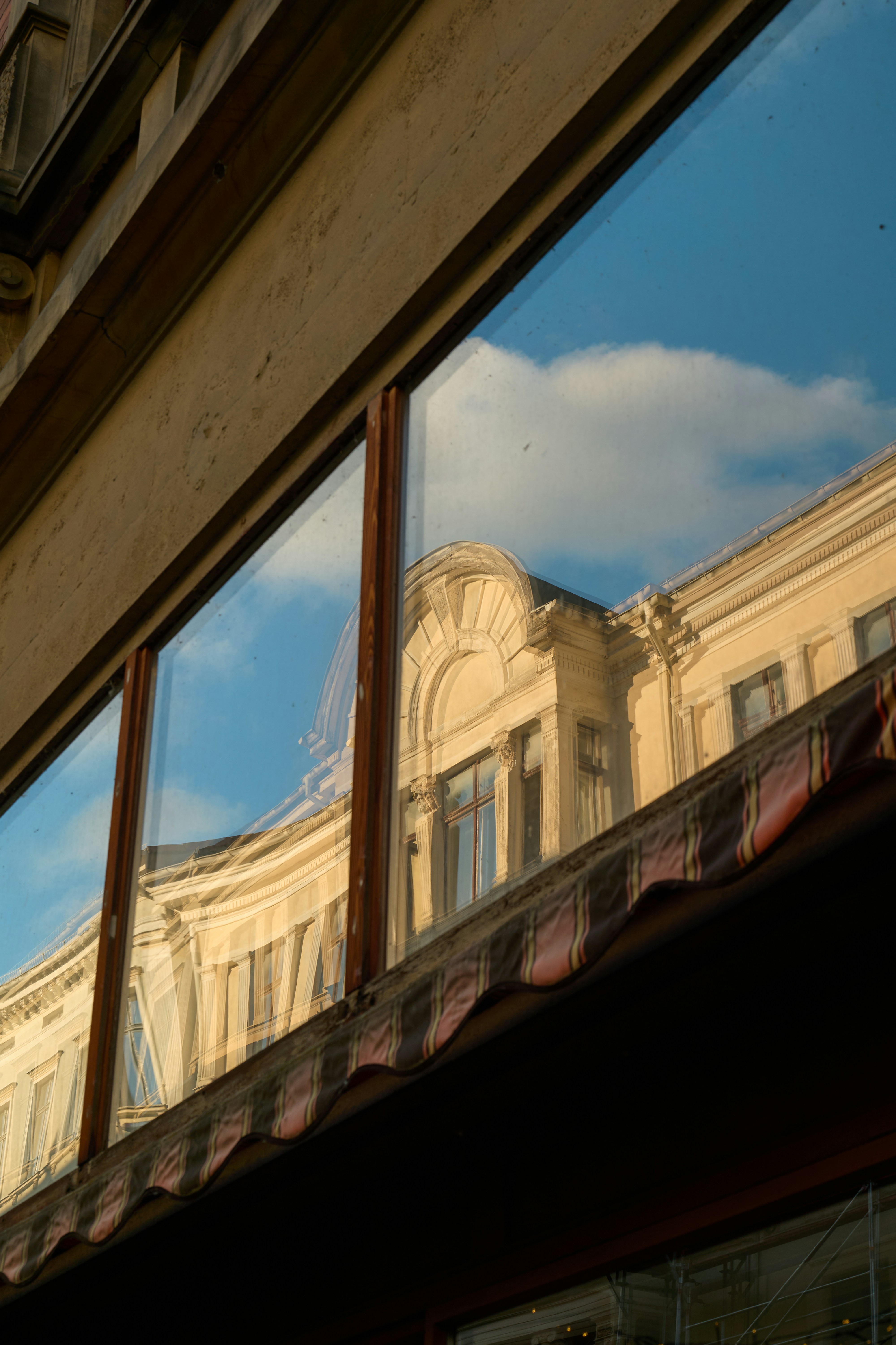 Reflected Facade: Historic Architecture Mirrored in a Shop Window