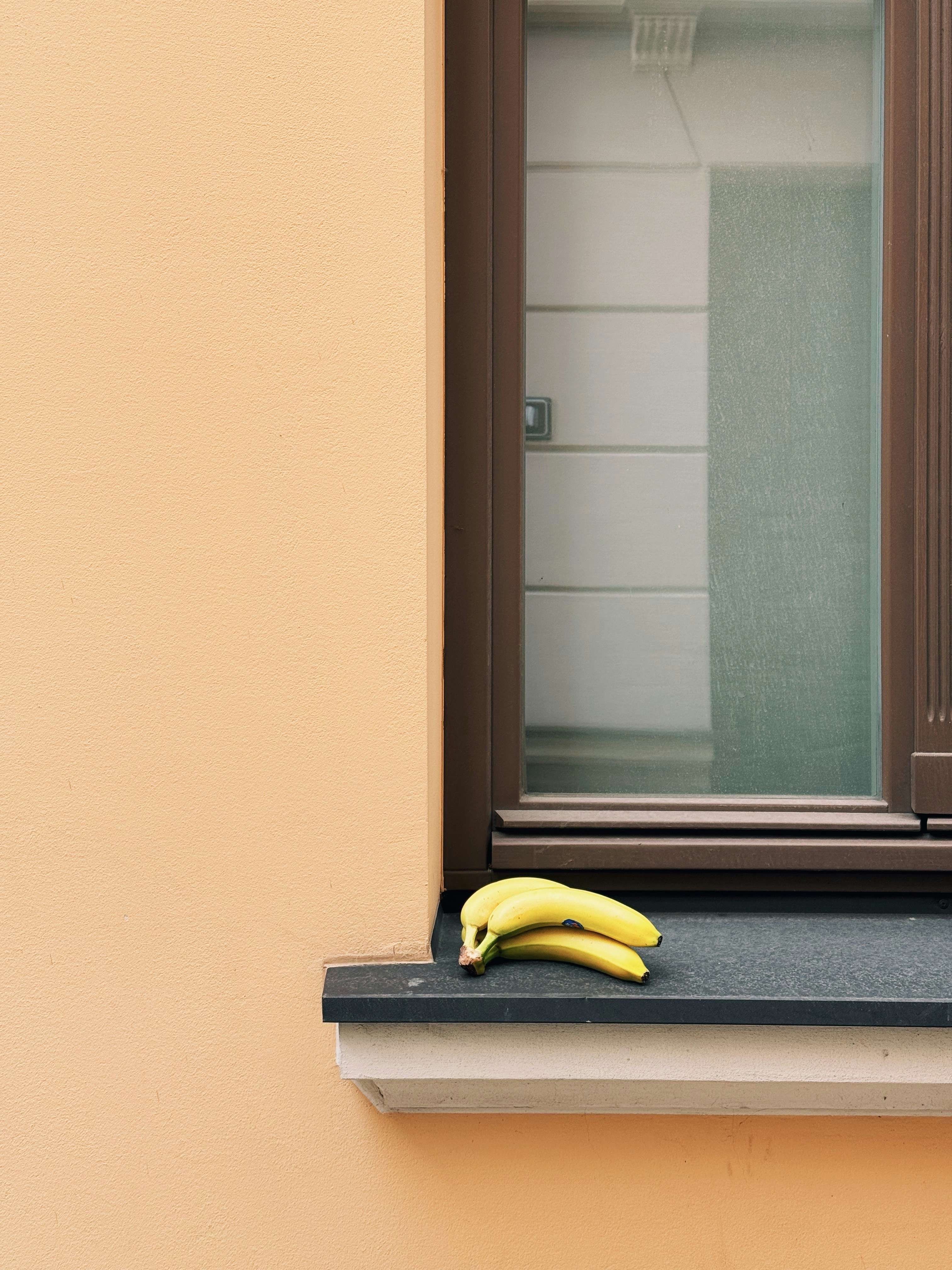 Banana on a Window Sill: Minimal Still Life Against Peach Wall