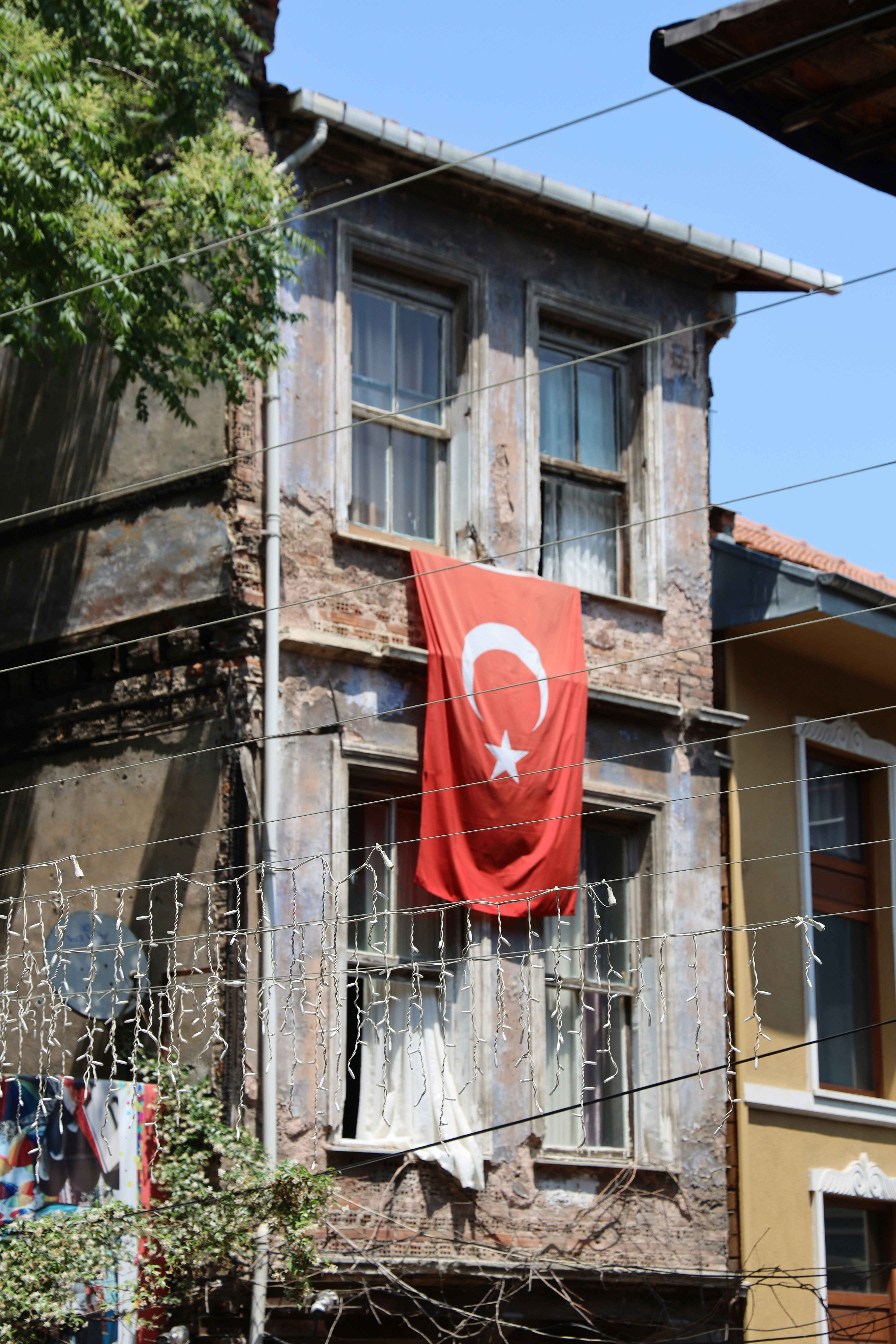 Tattered Facade with Turkish Flag: A Silent Balcony