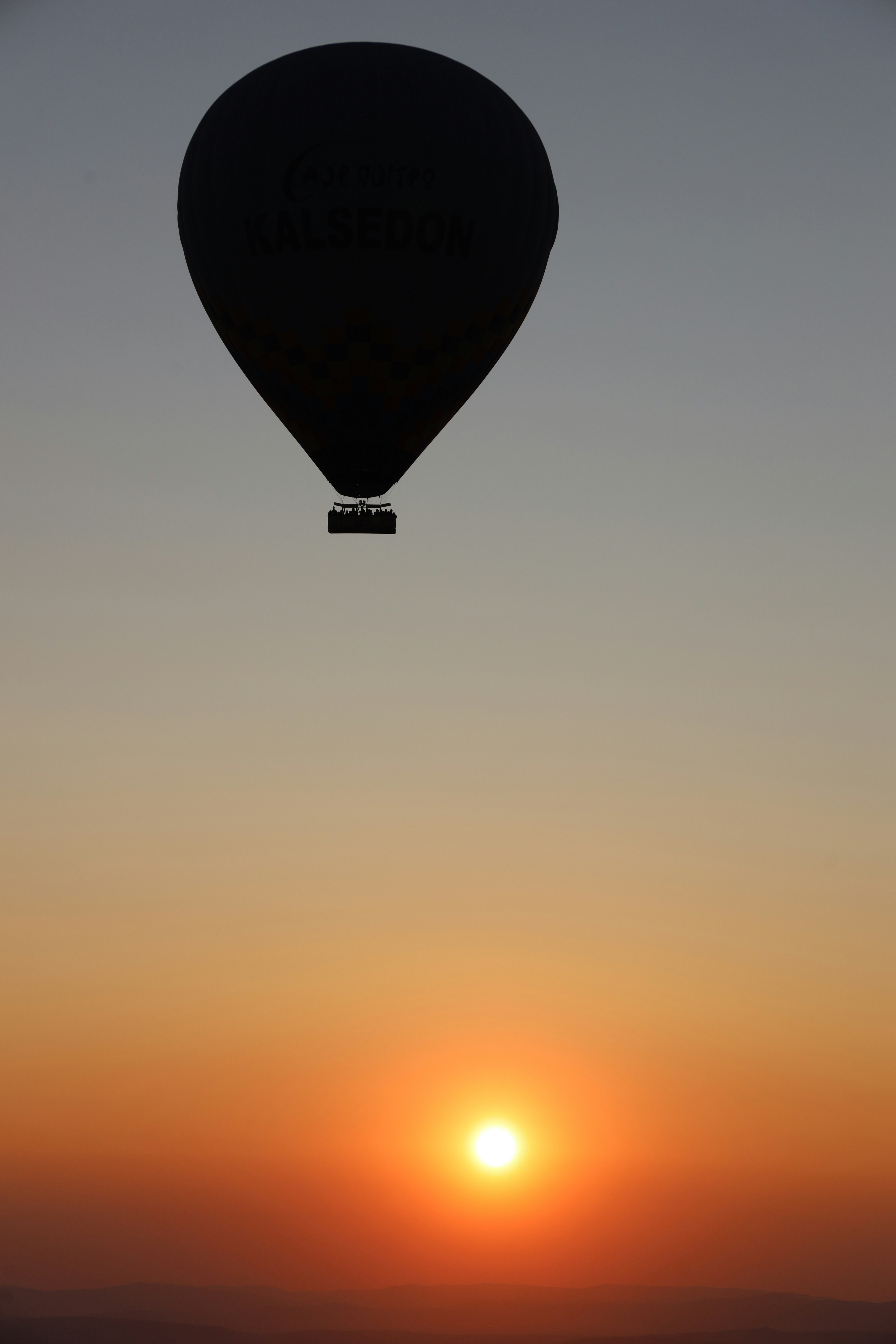 Silent Descent: Ballon Silhouette Above a Golden Horizon