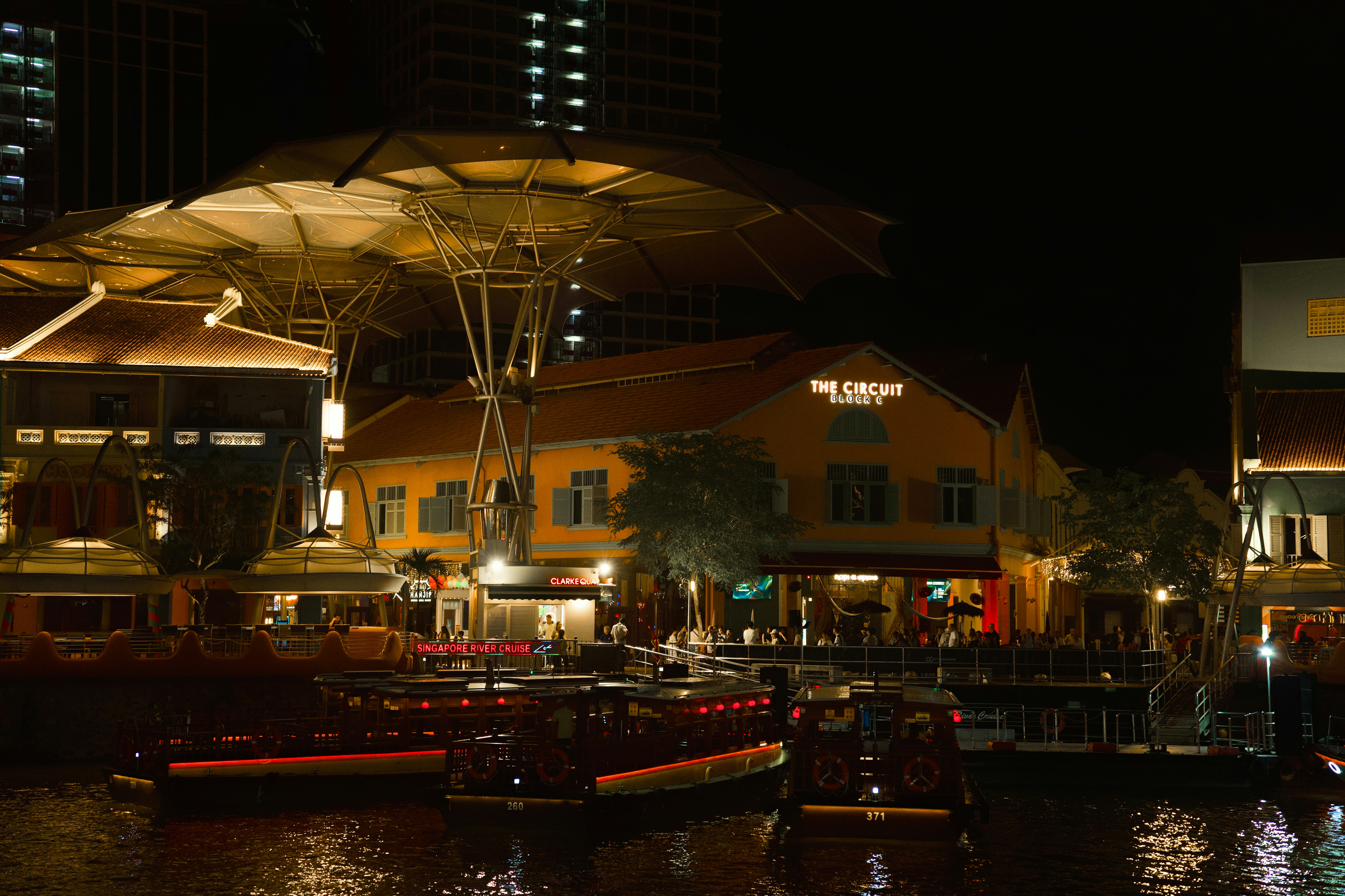 Harborfront After Dark: Warm Lights and Floating Boats