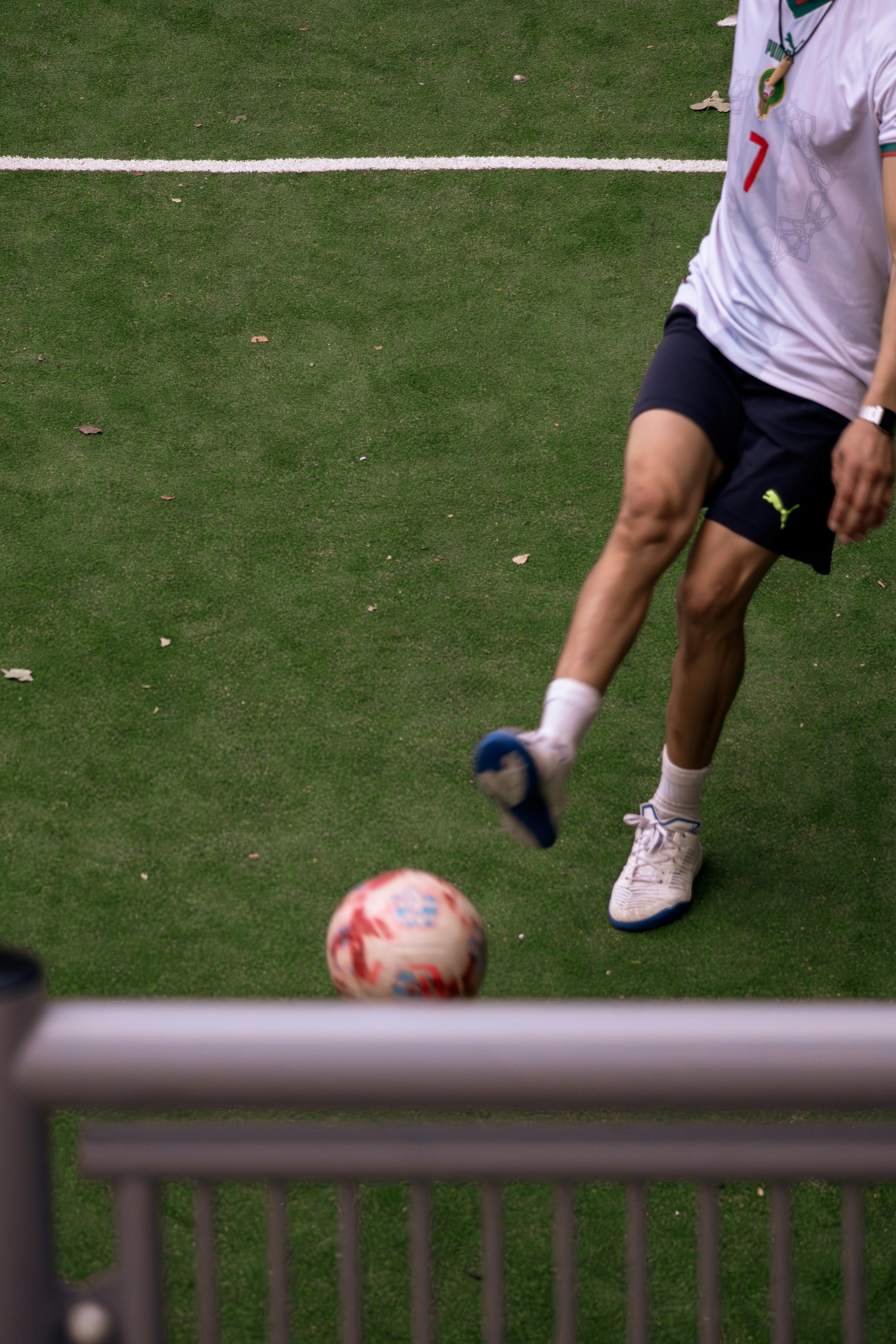 Midfield Sprint: A Player Tracks the Ball on a Green Pitch