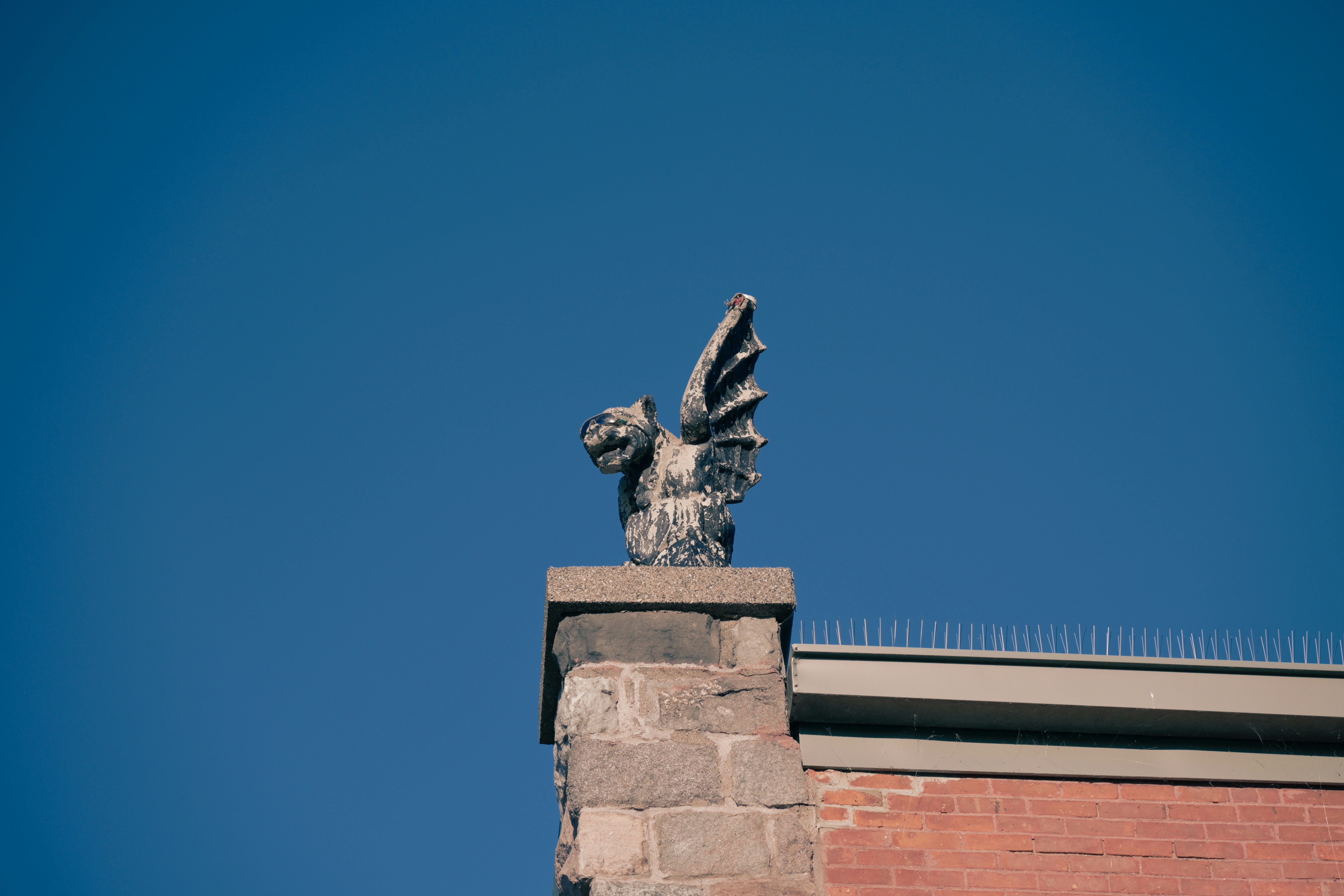 Winged Stone Guardian Above the Brick Verge