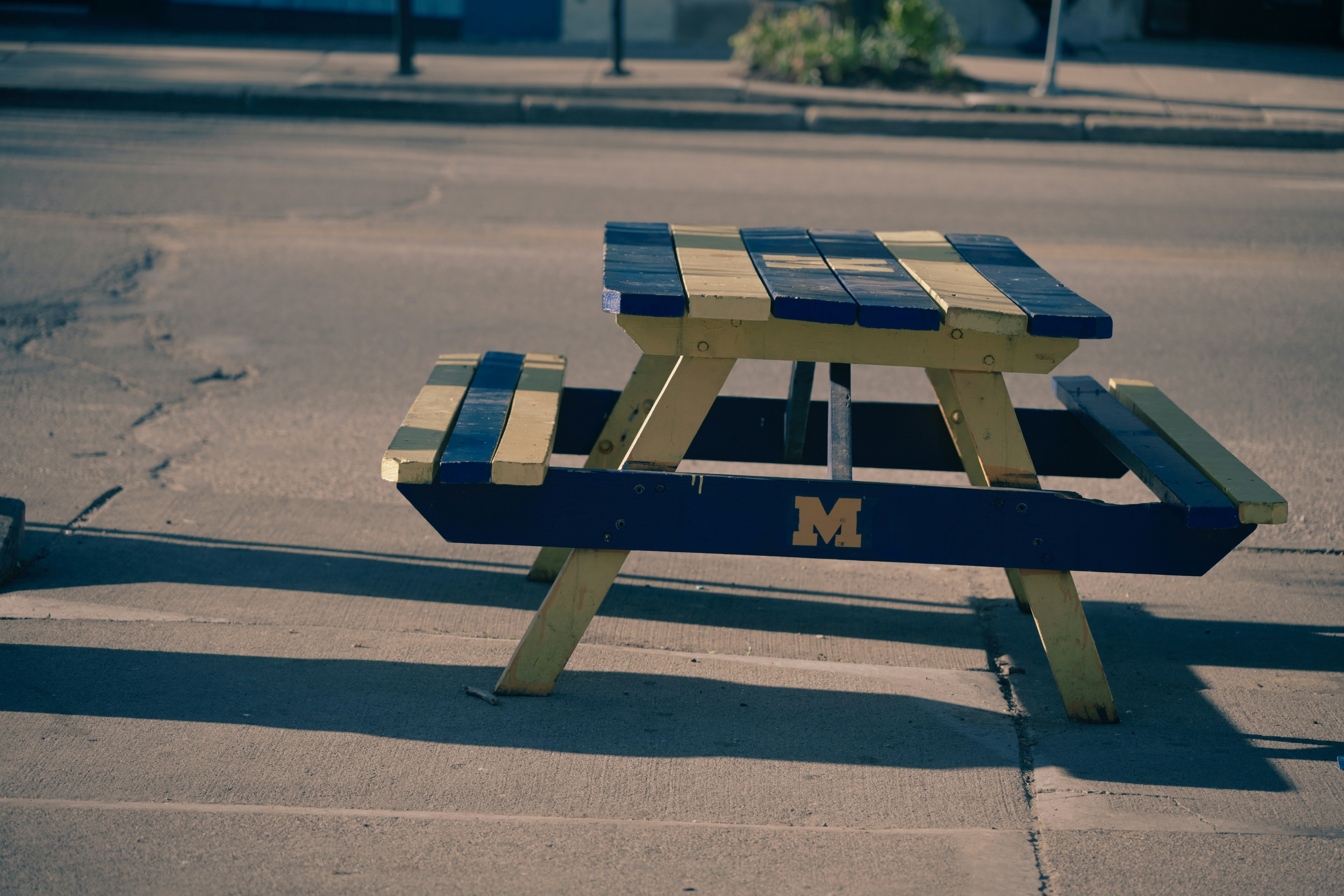 Muted Blue and Cream Picnic Table Under Streetlight Shadows