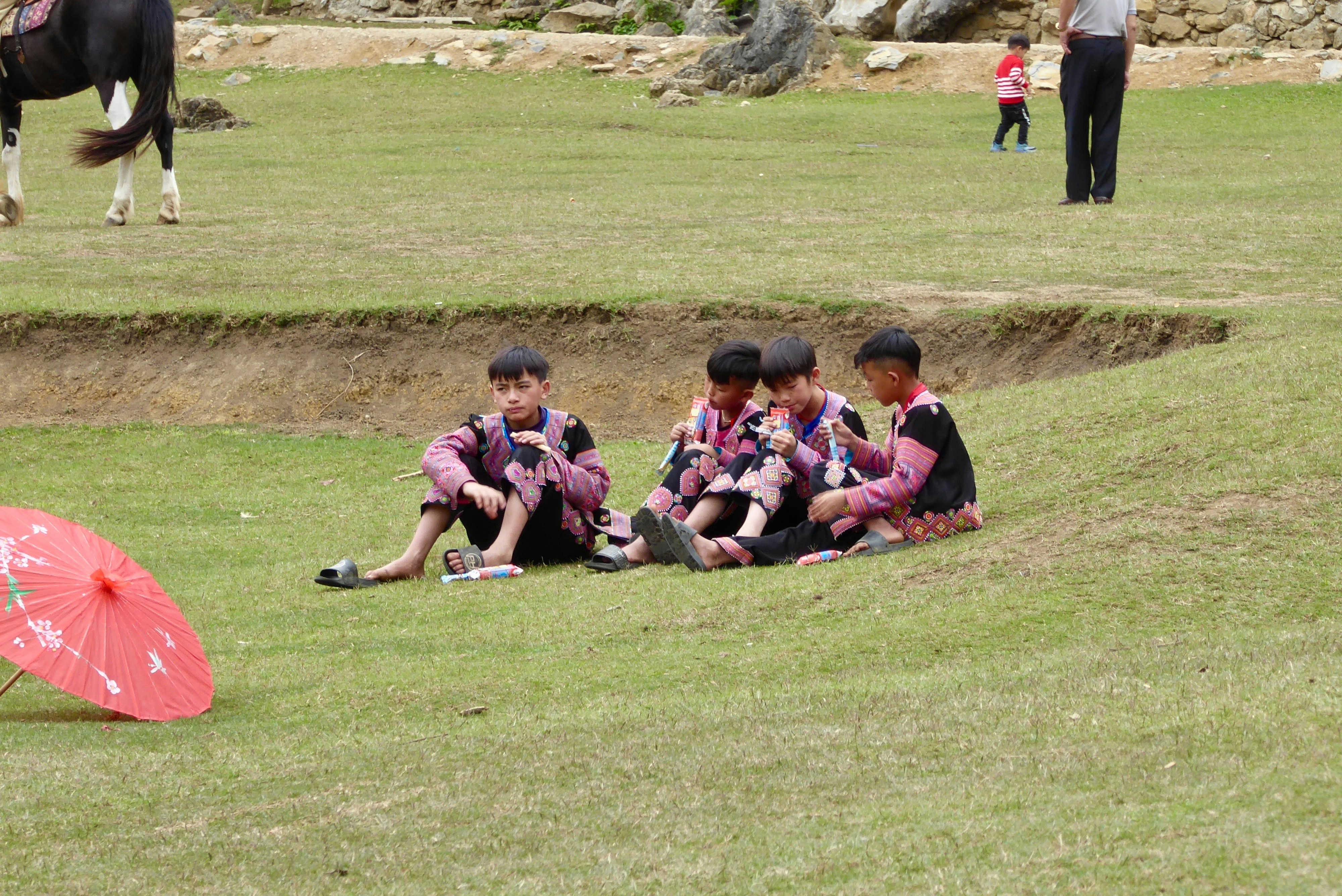 Late Afternoon Break: Four friends in coordinated uniforms resting on the grassy field