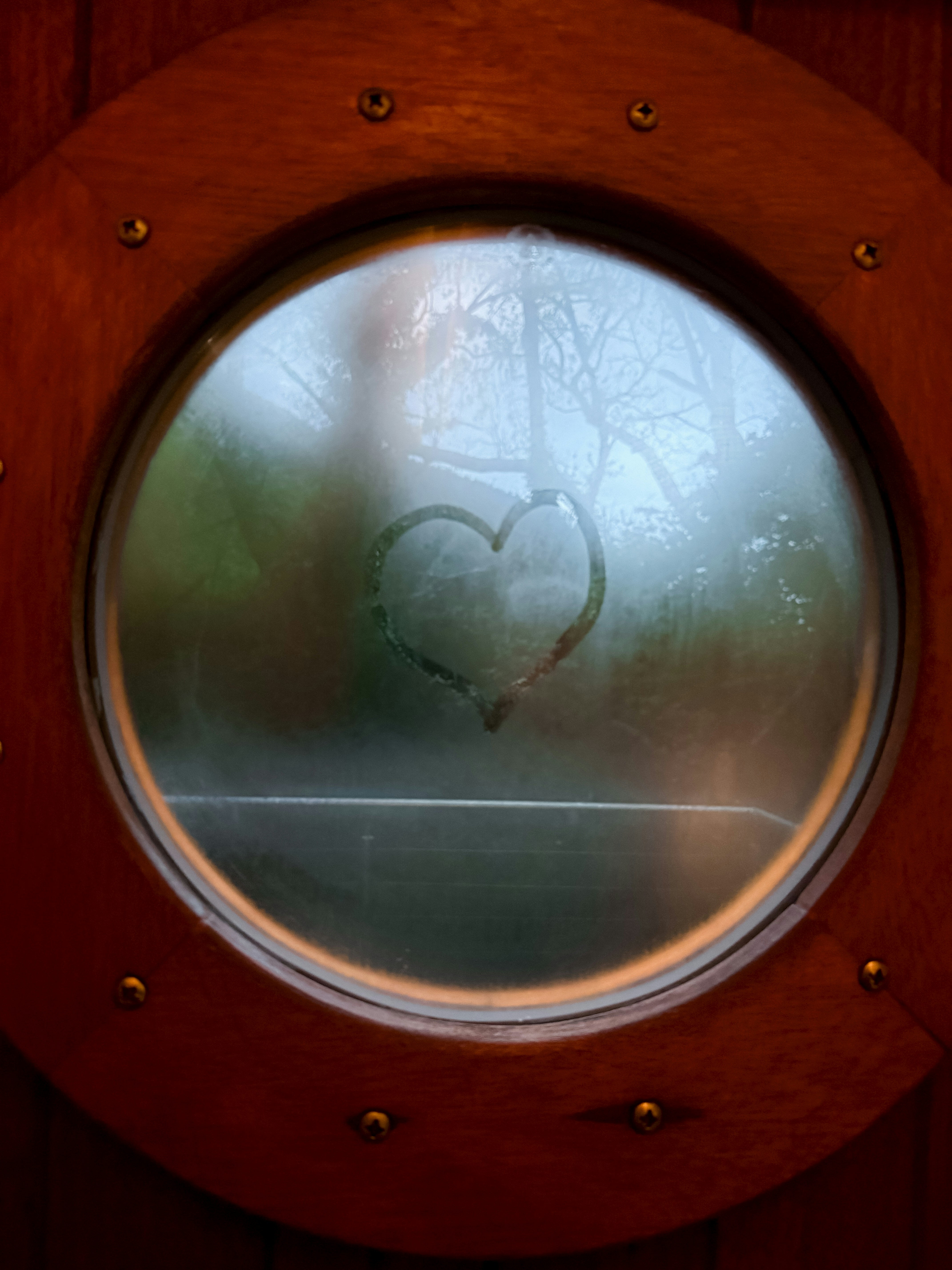 Heart on Frosted Glass: A Quiet Moment Through the Round Window
