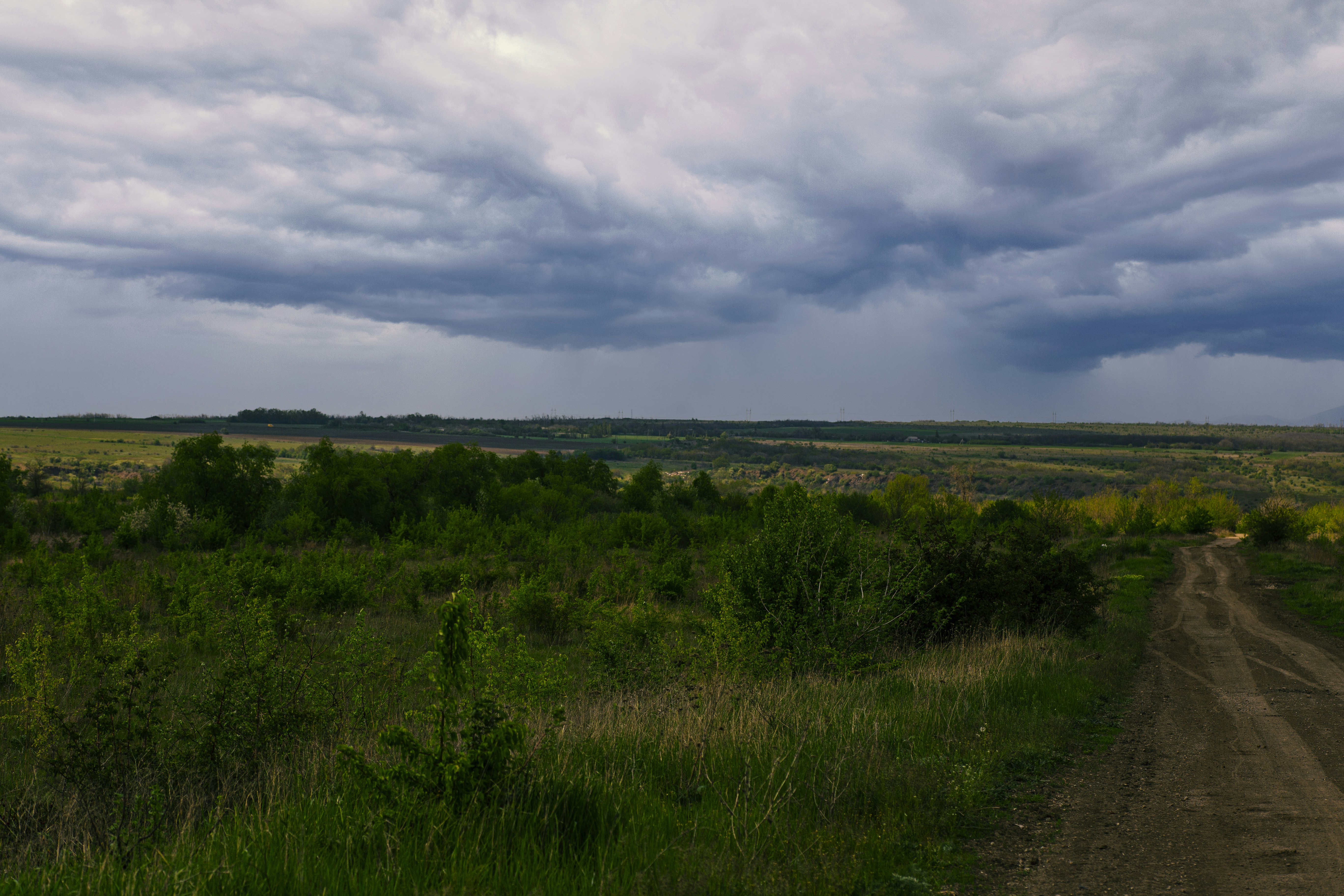 Storm Approaches Over the Prairie Road
