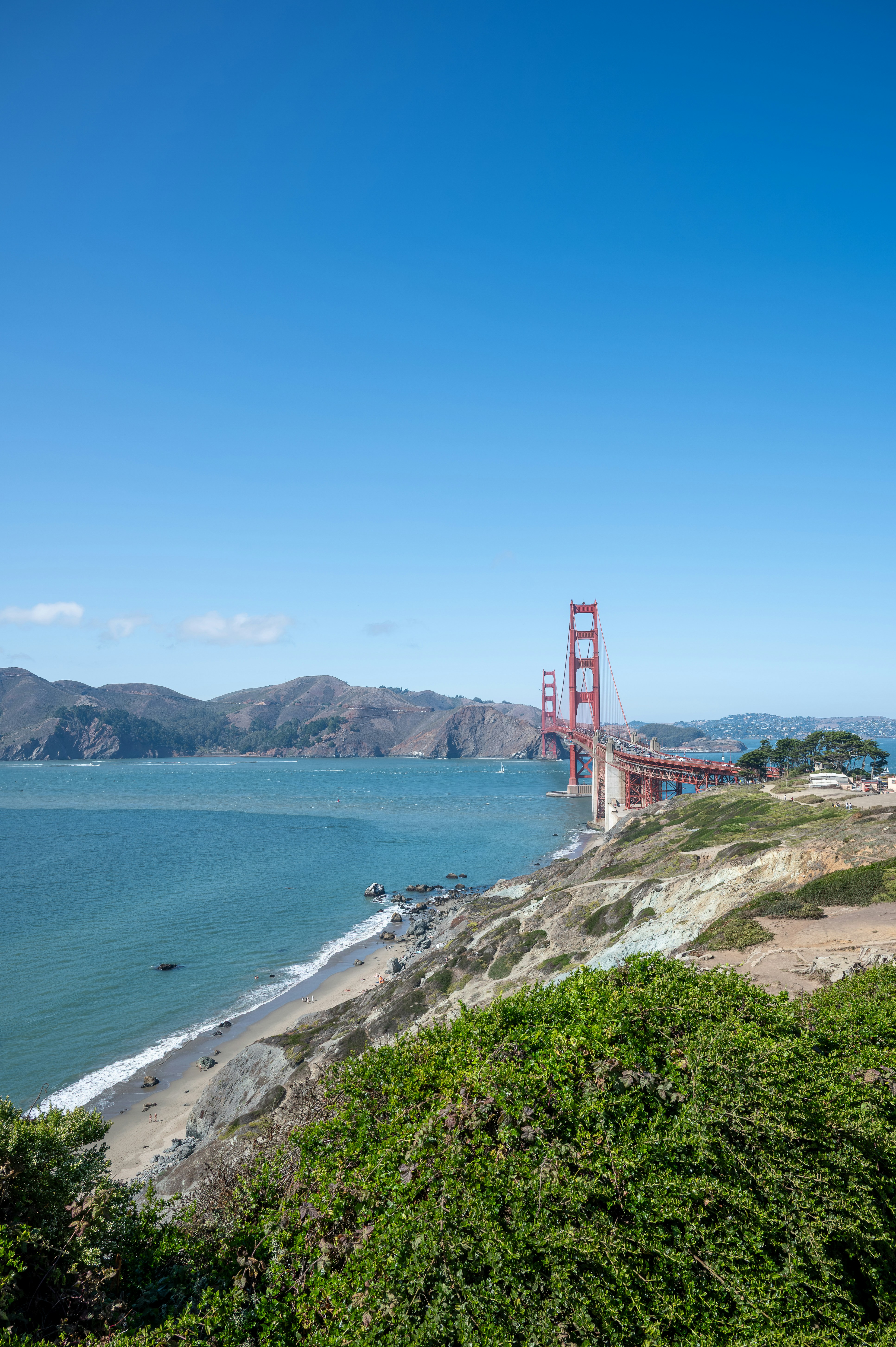 Red Bridge on the Horizon: A Coastal Vista from the Clifftop