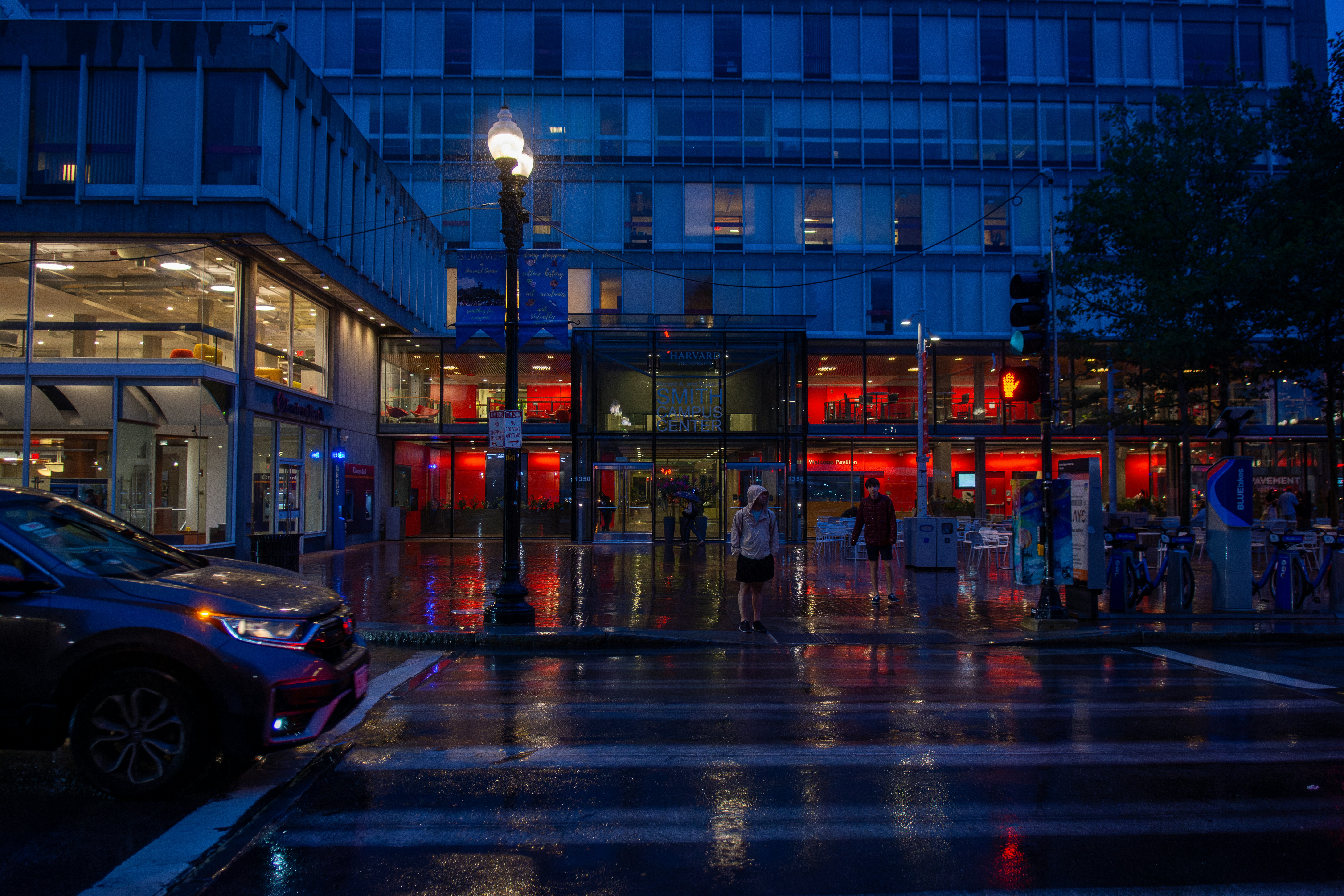 Neon reflections on a rainy urban storefront after dusk