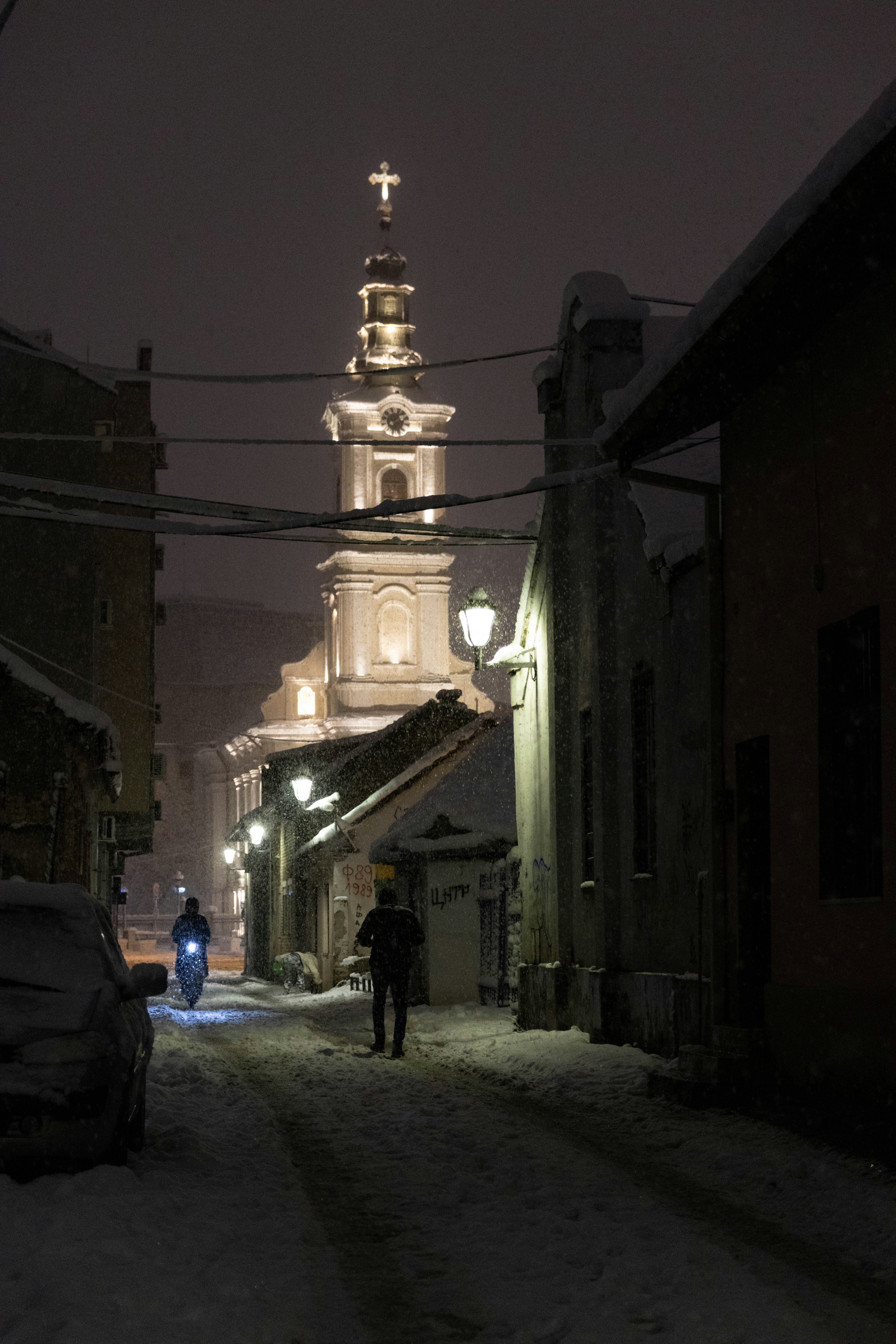 Snowlit Steeple Amid Narrow Night Alleys