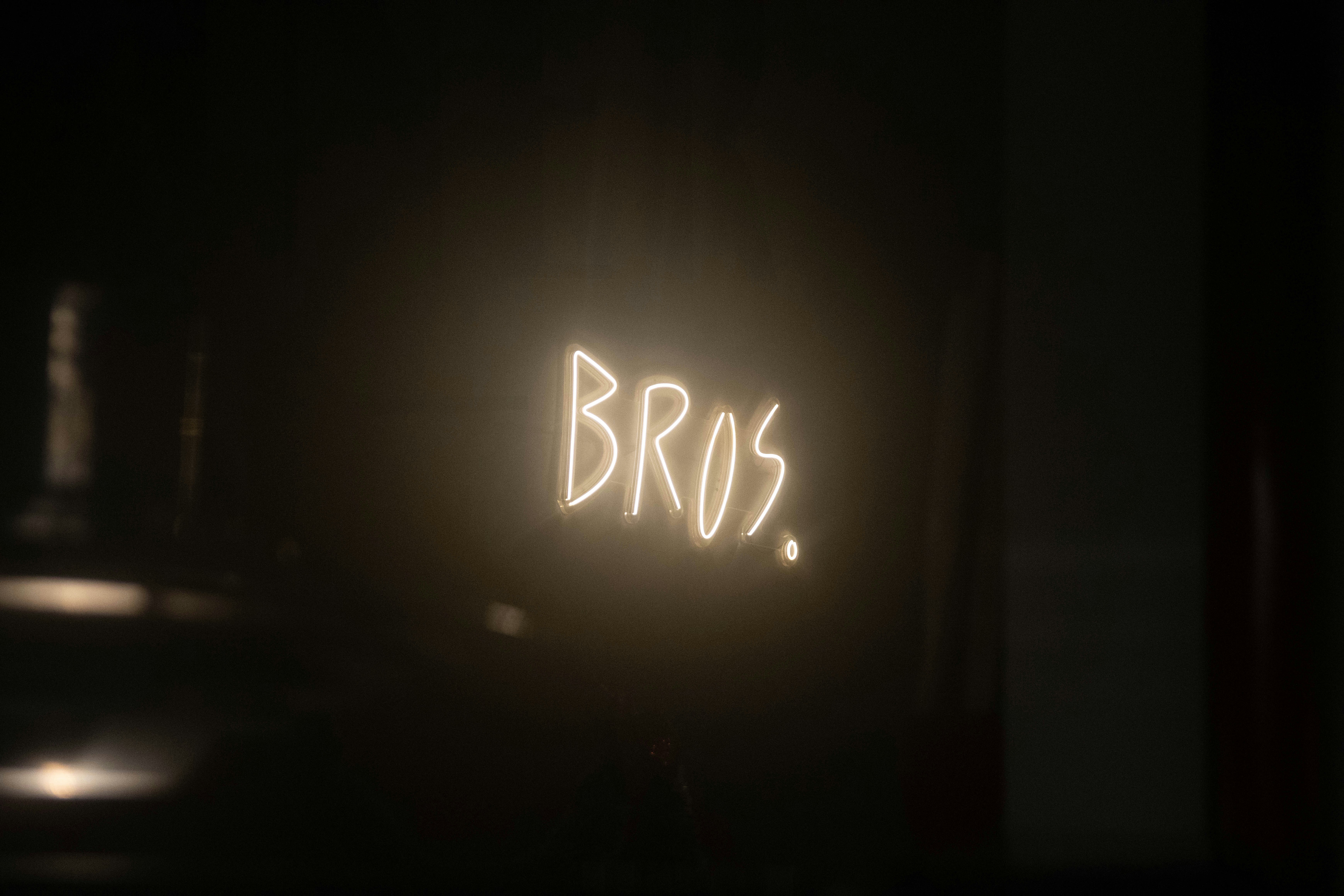 Glowing “BROS.” in a moody night scene