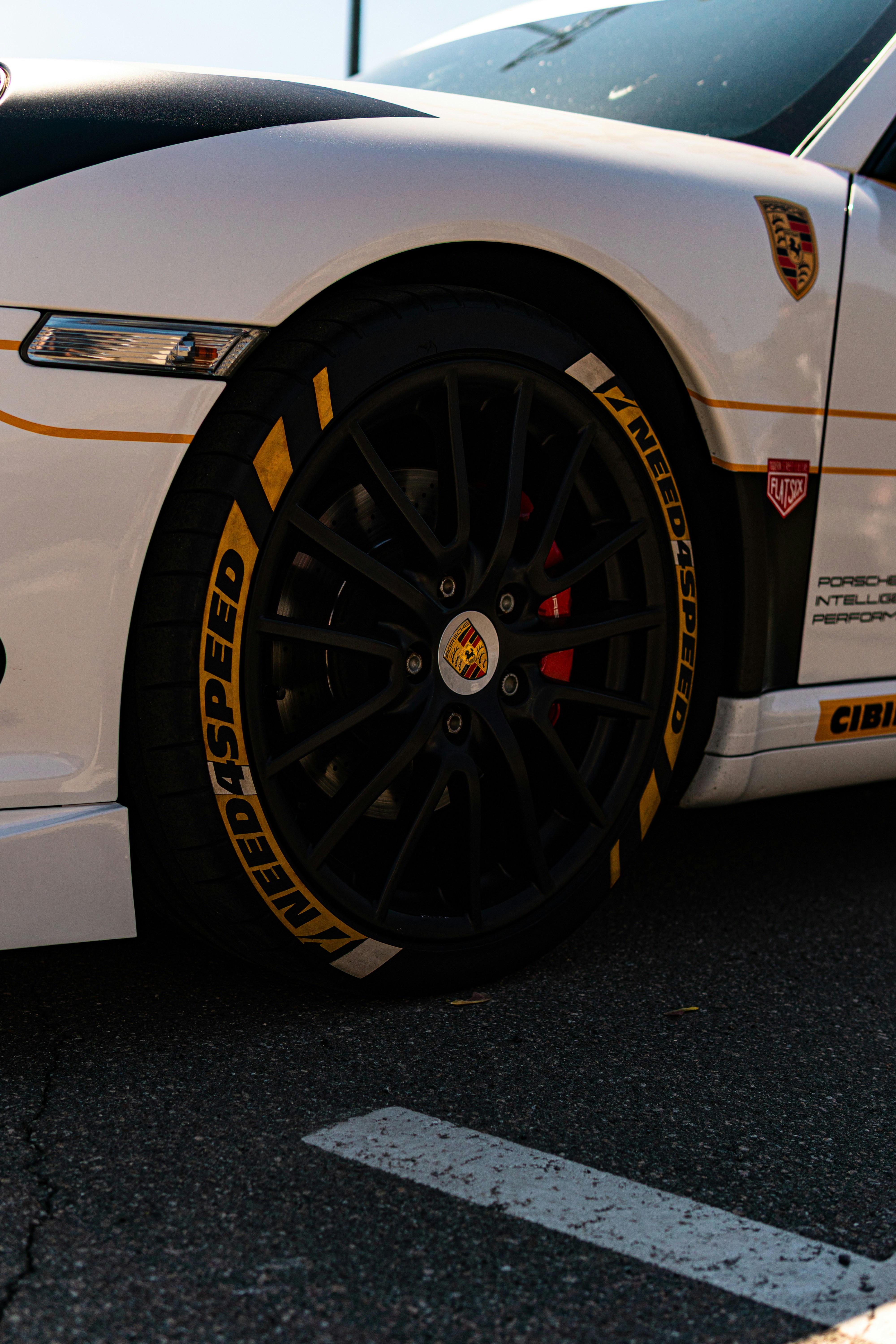 Porsche Precision: Close-Up of a Wheel and Badge in Motion-Ready White