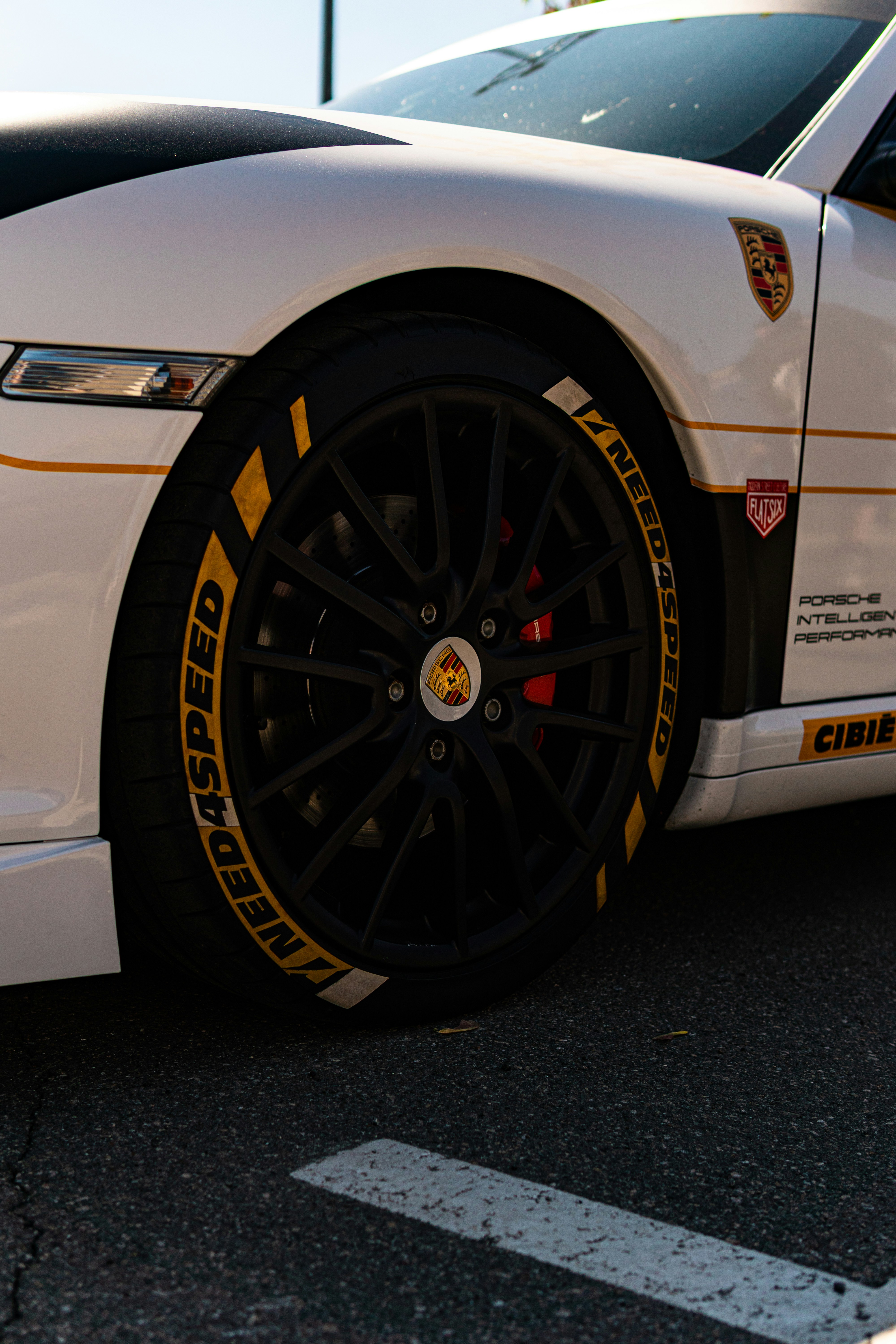 Black-rimmed Porsche Pride: A Close-up of the White Racer’s Wheel