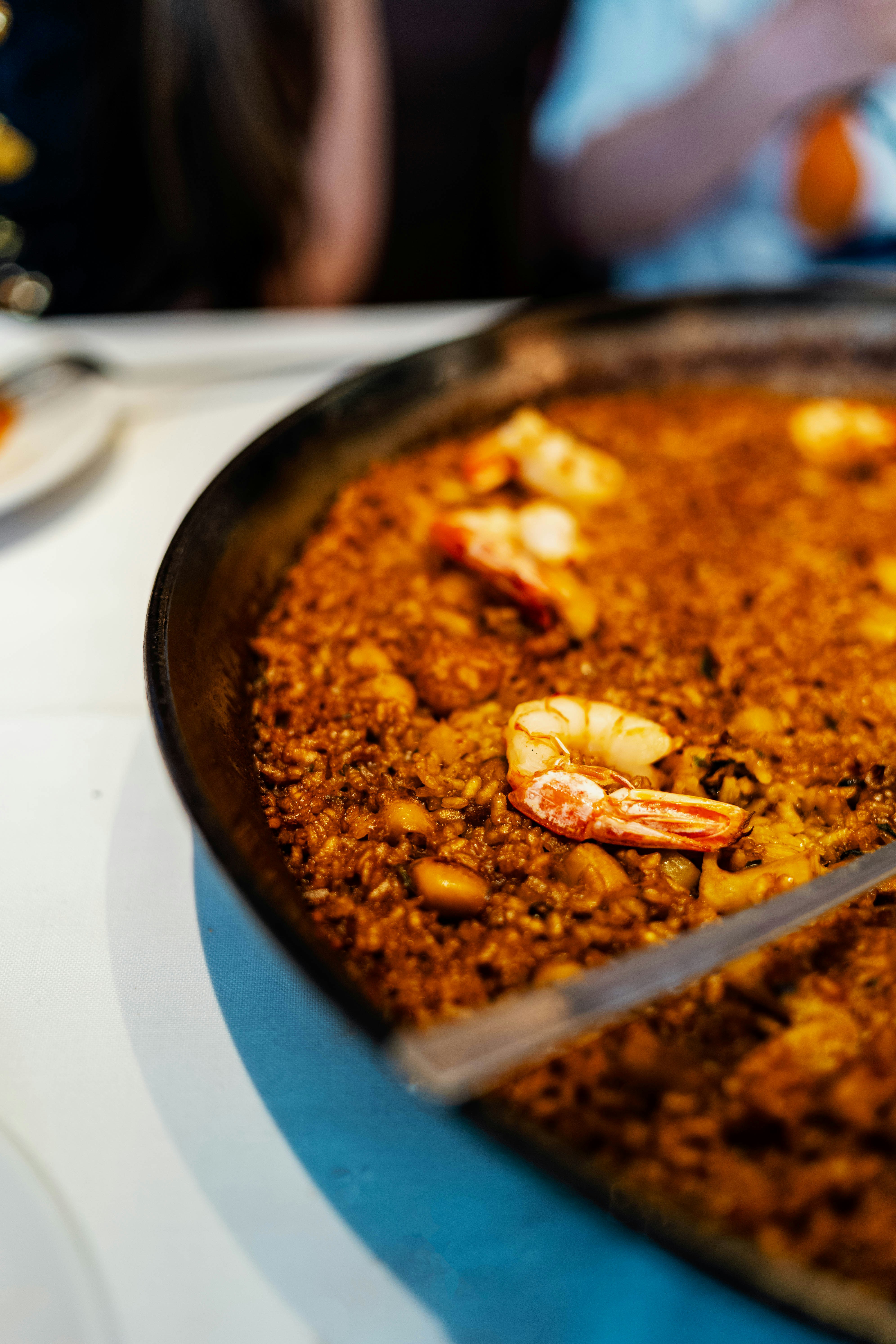 Shrimp paella in a sizzling skillet captured from an overhead angle