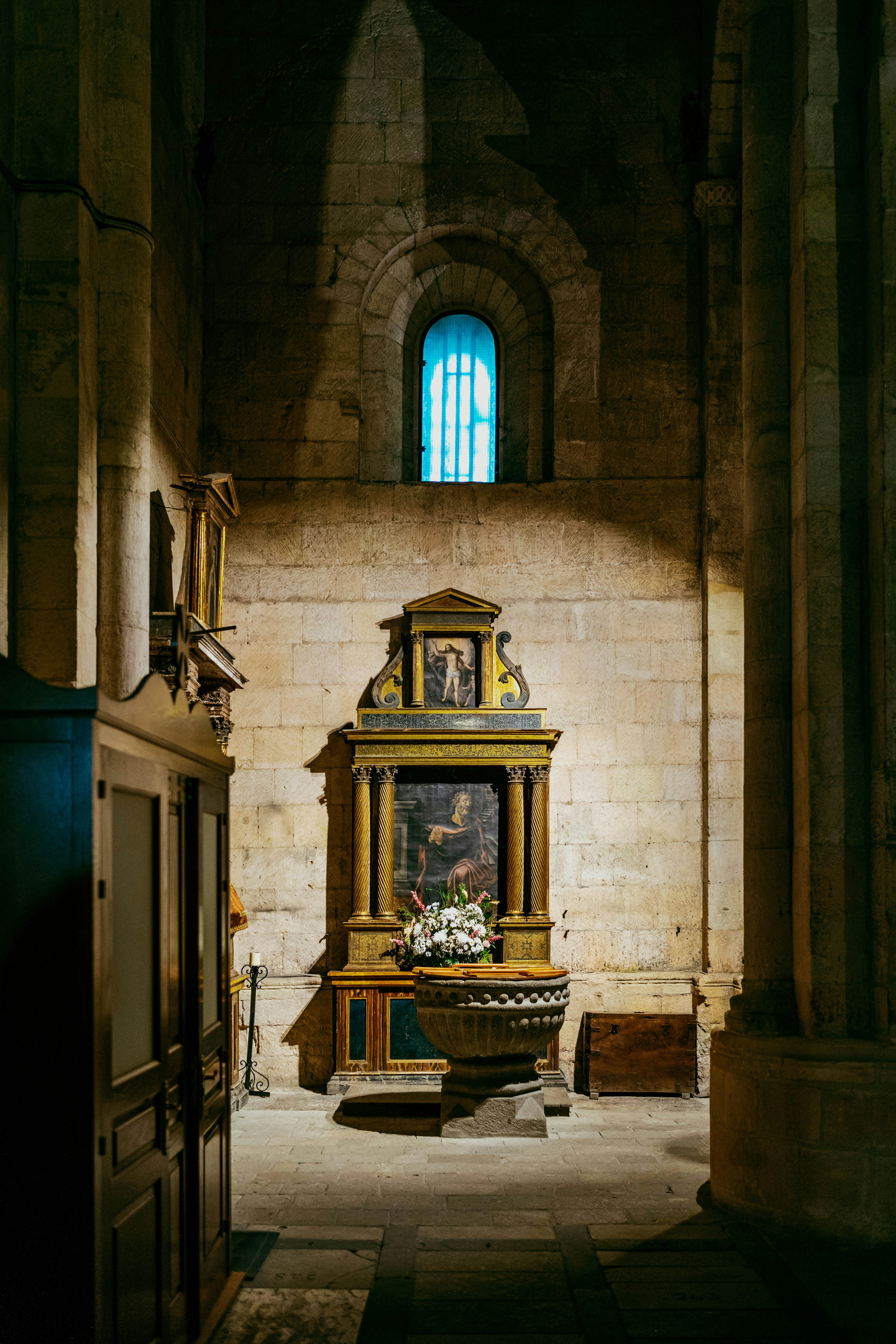 Quiet Shrine: A Saintly Altar Beneath a Narrow Blue Window