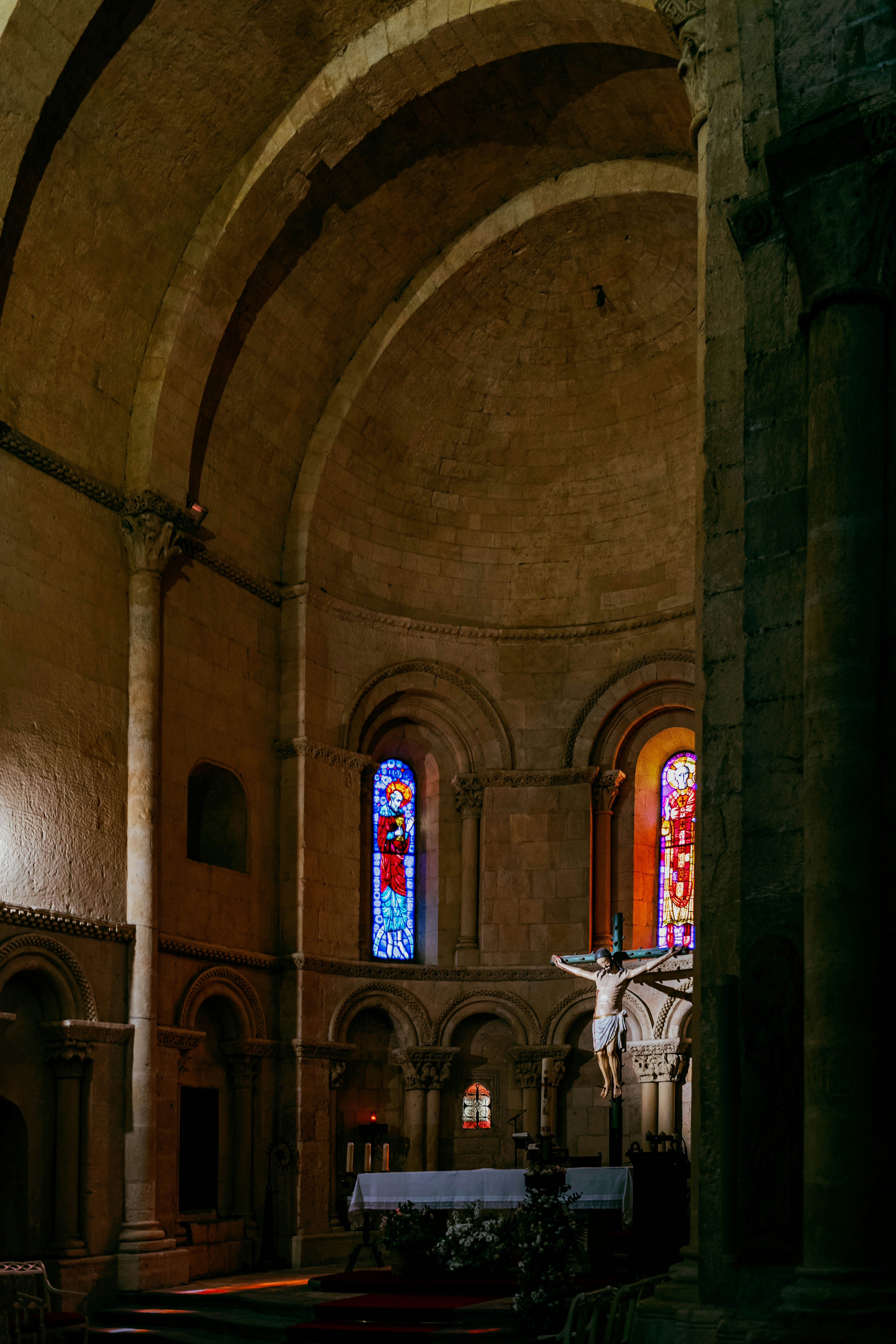 Cruciform Quiet: A Dim Interior Framed by Stained Windows