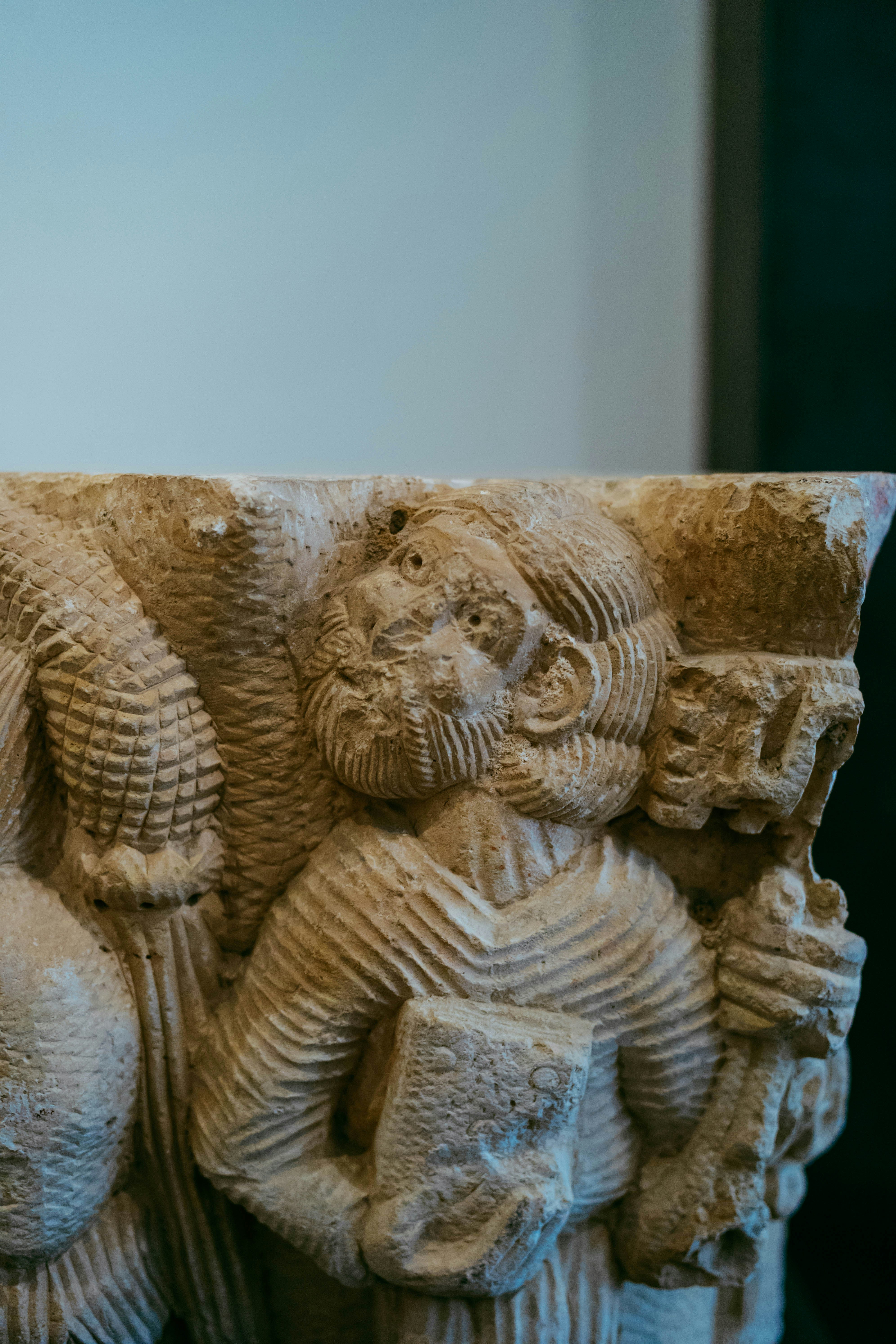 Carved Scholar in Stone: A Weathered GreeK-inspired Figure Emerges from the Pillar