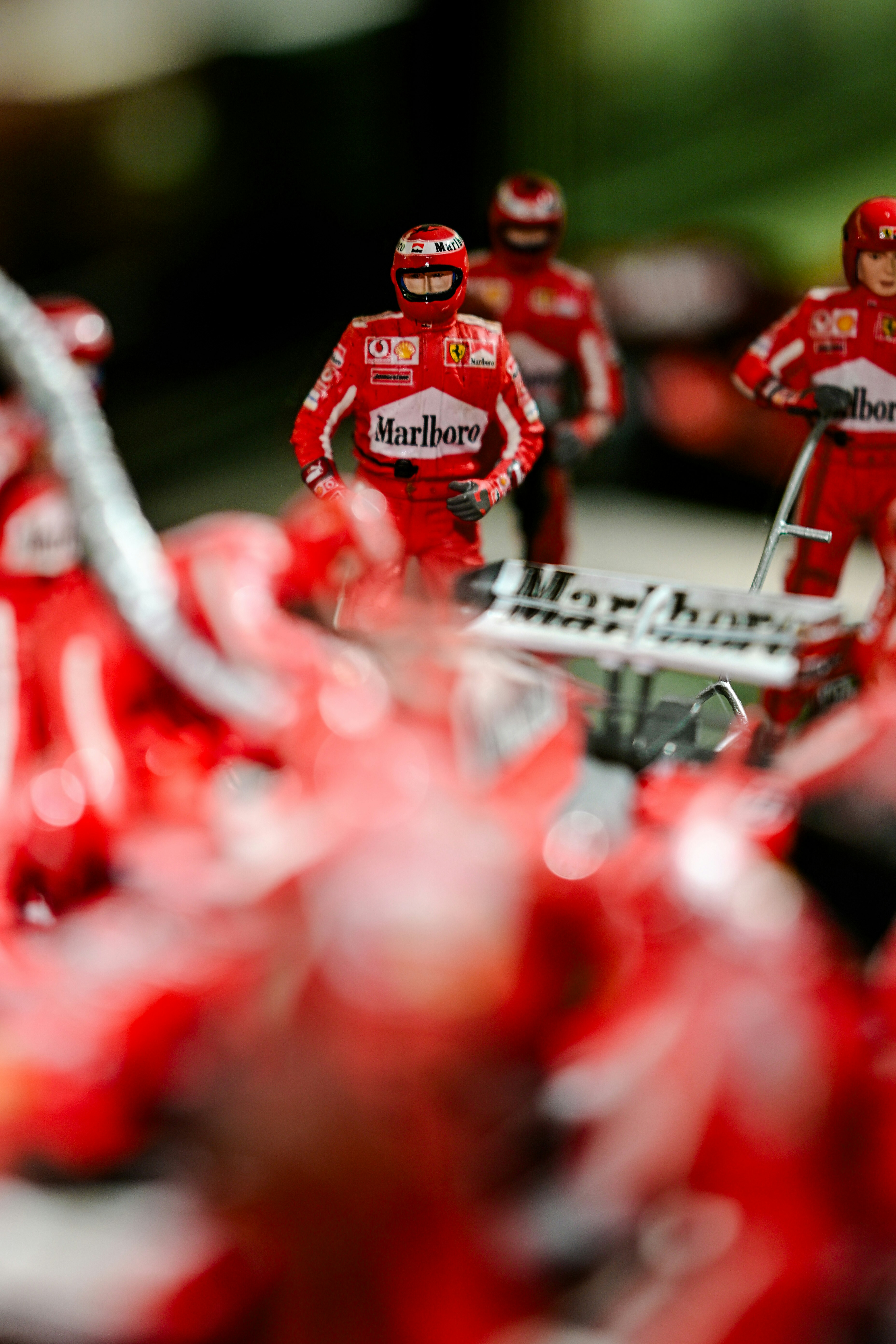 Ferrari team portrait: focus on the red-suited driver amid a sea of miniature racers