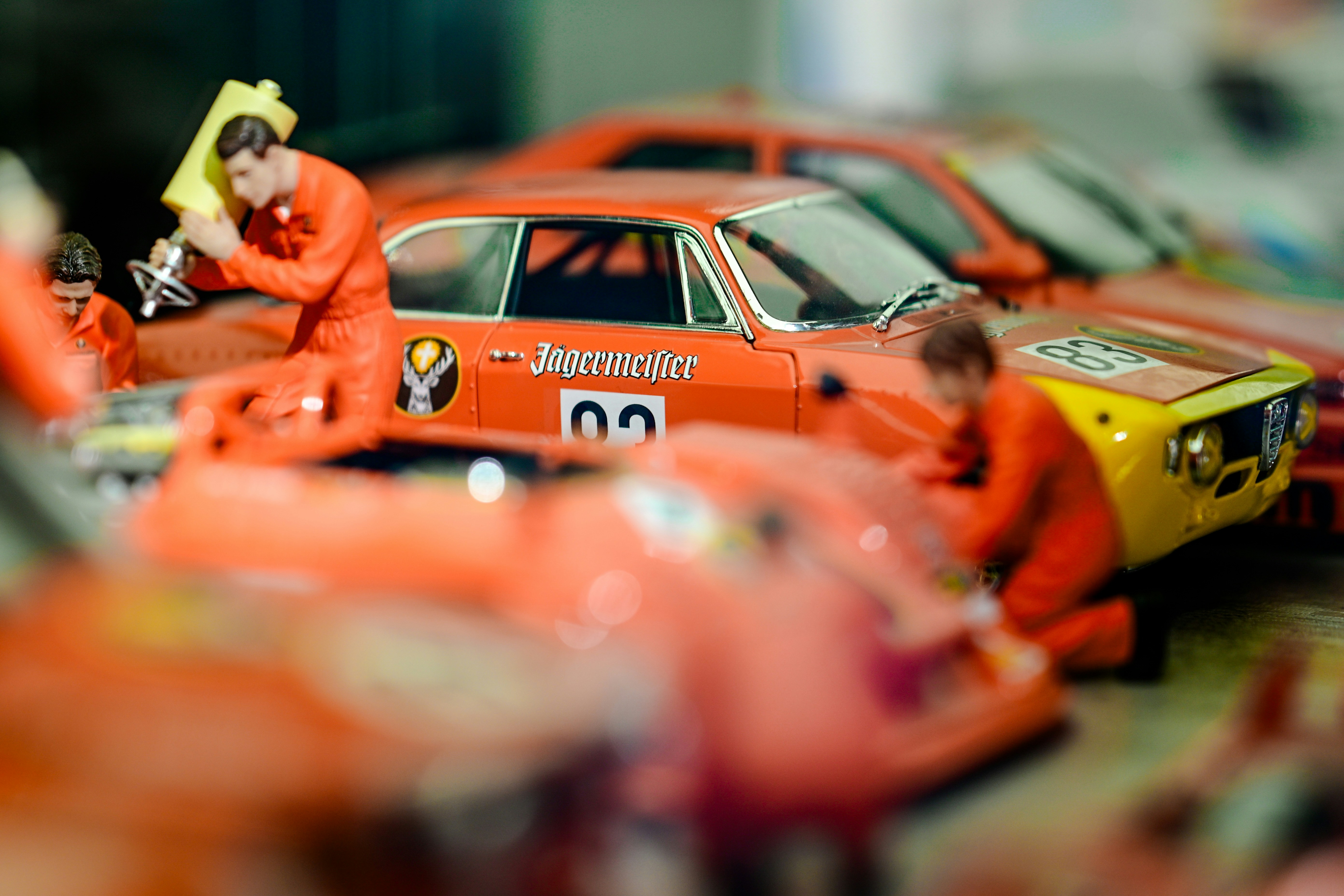 Tiny Pit Crew in Red Overalls Tinkering with a Jagerndorfer Classic