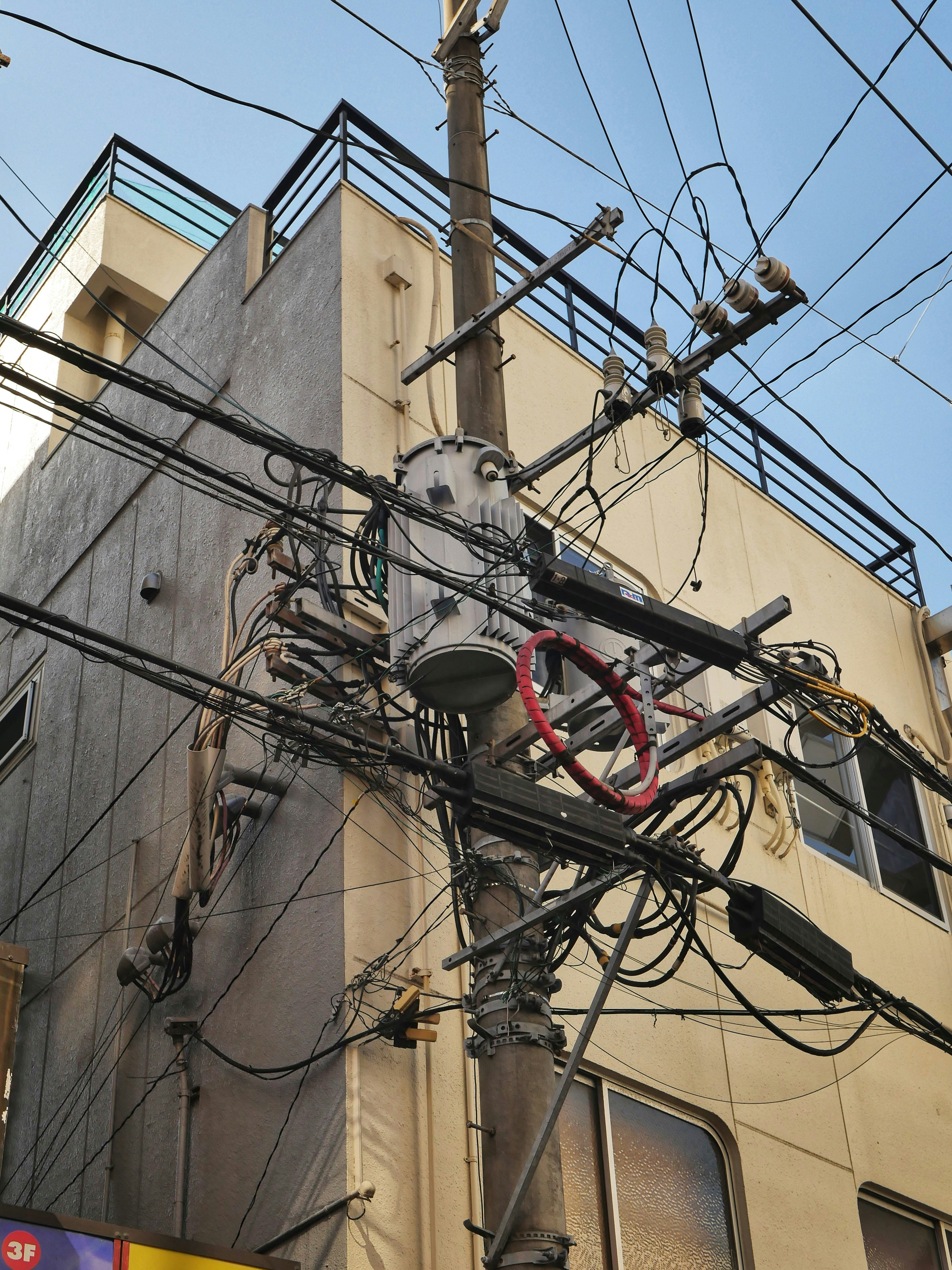 Urban Tangle: The Conduit of Wires Amid a Sunlit Building