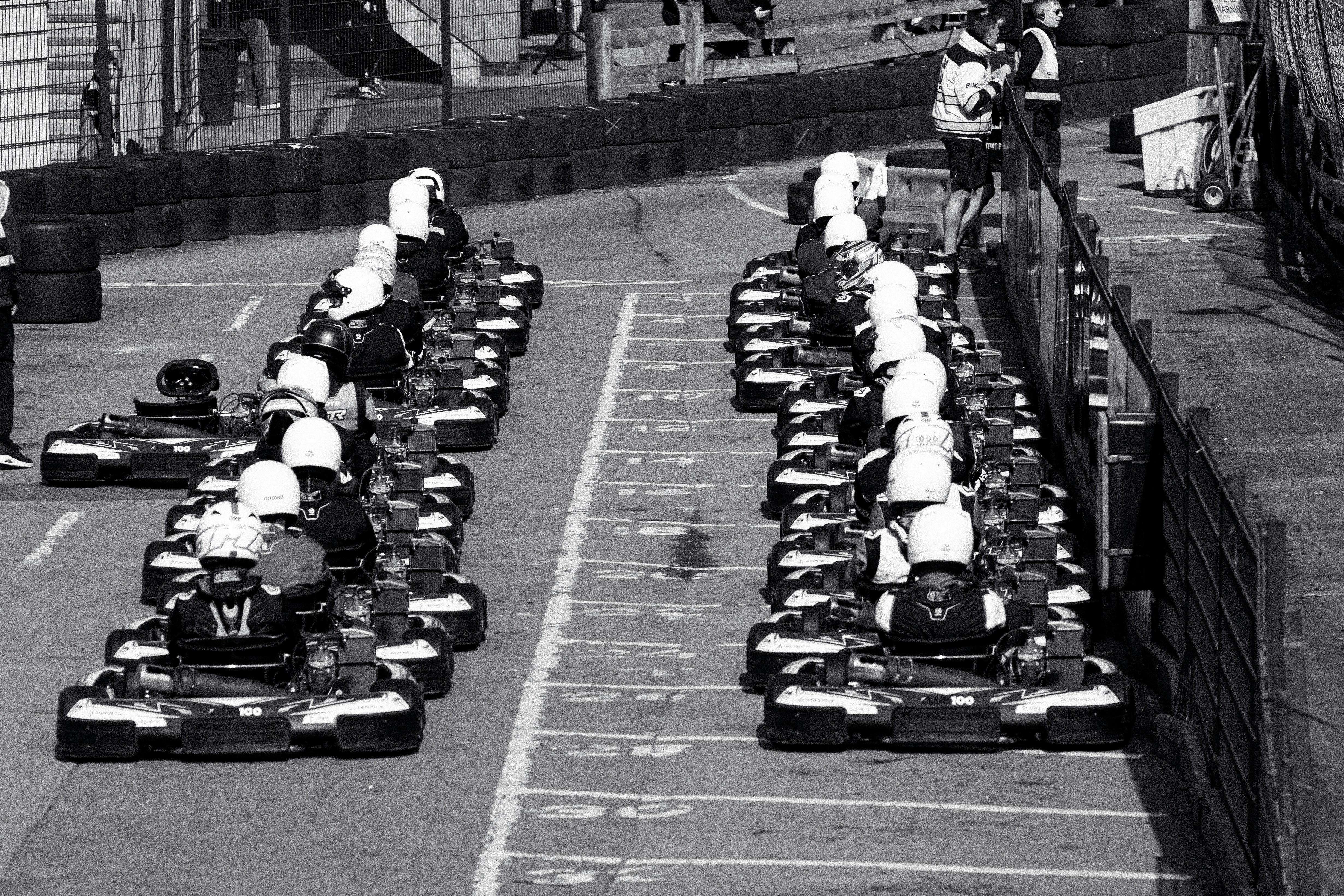 Row of Go-Karts Aligning Toward the Turn, Riders in Line