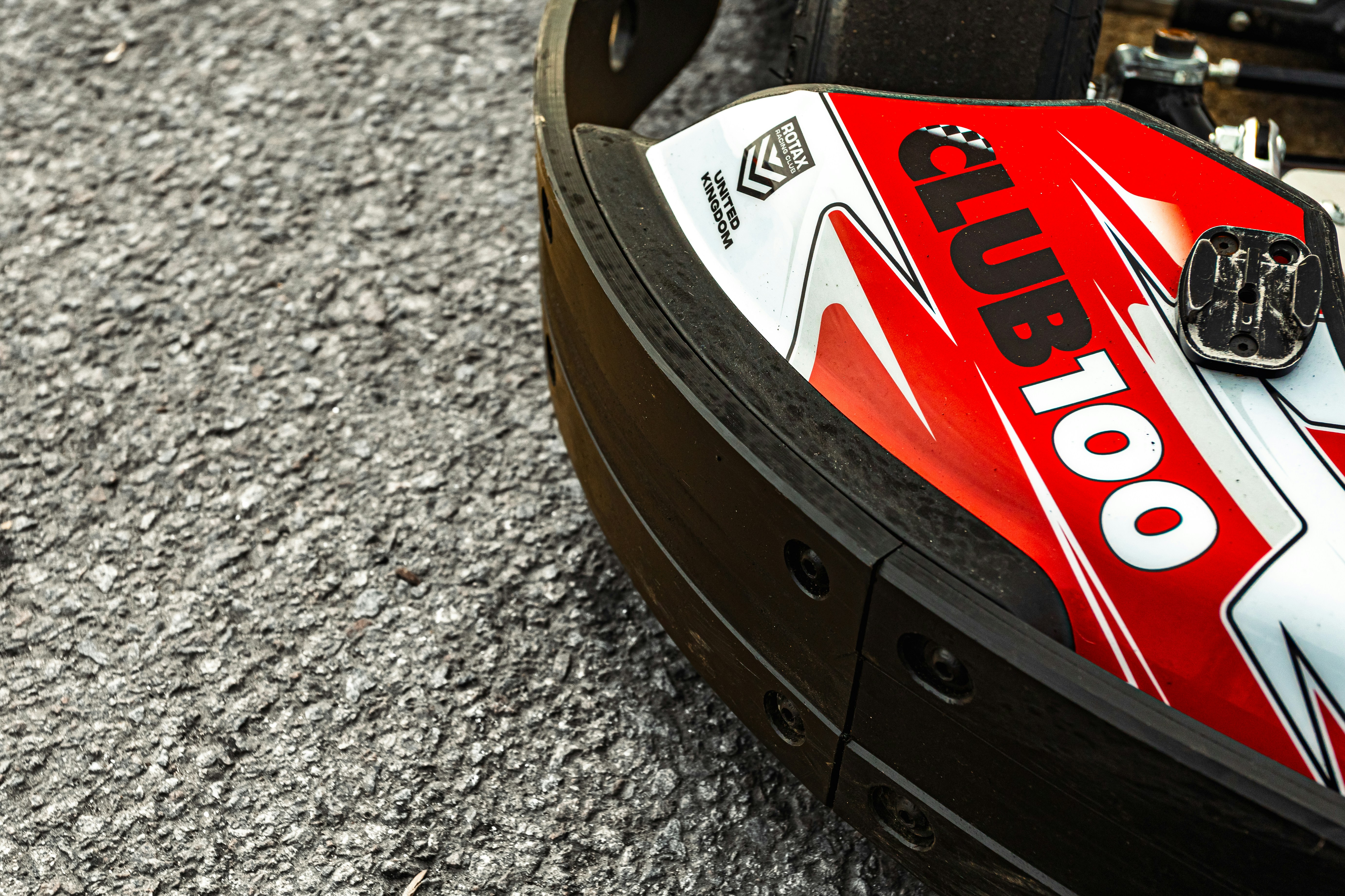 Red Go-Kart Bodywork ingrain: A Close-Up of a Racing Helmet and Wheel Rim