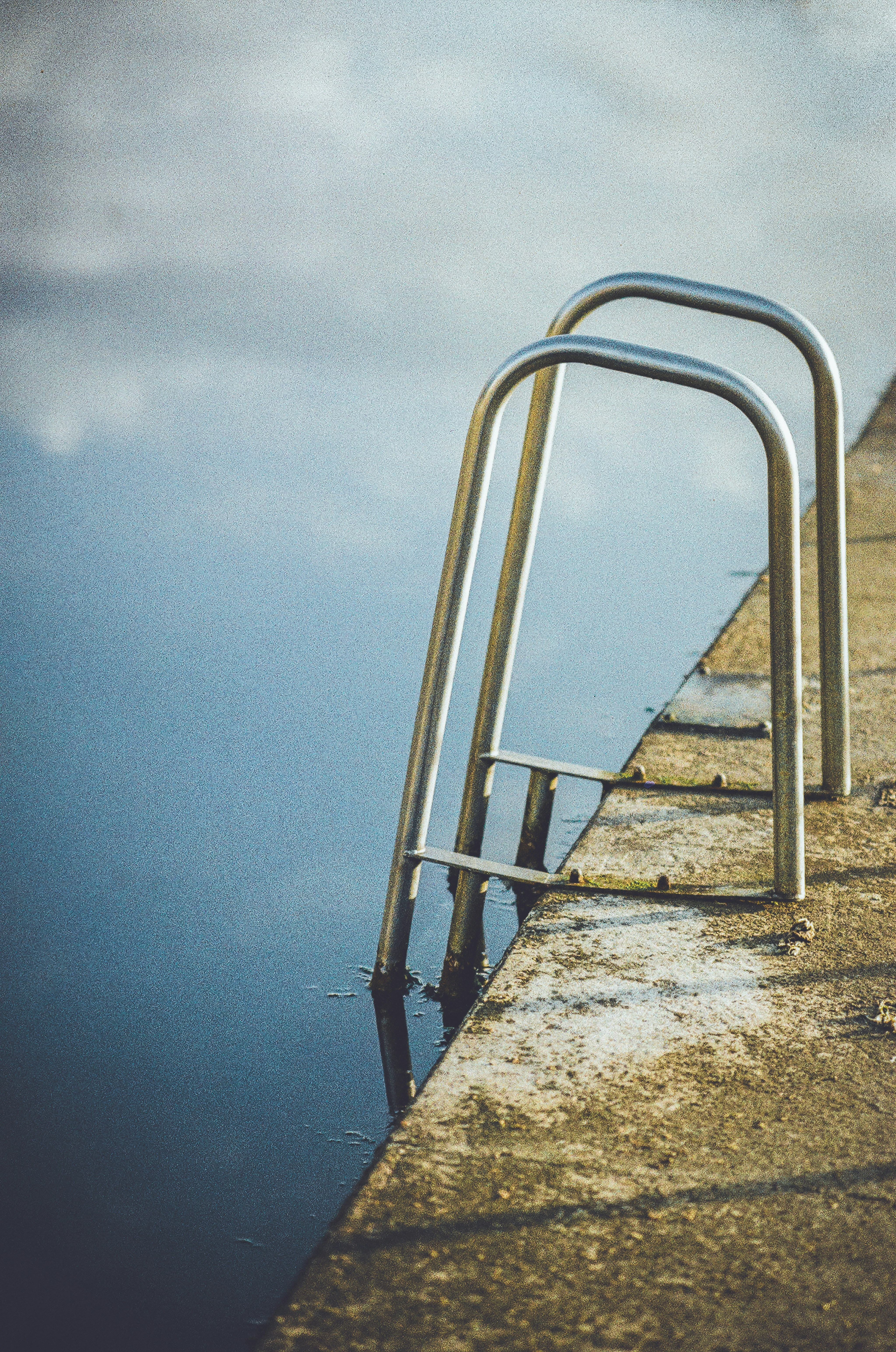 Vertical Railing Reaching Over a Quiet Pool