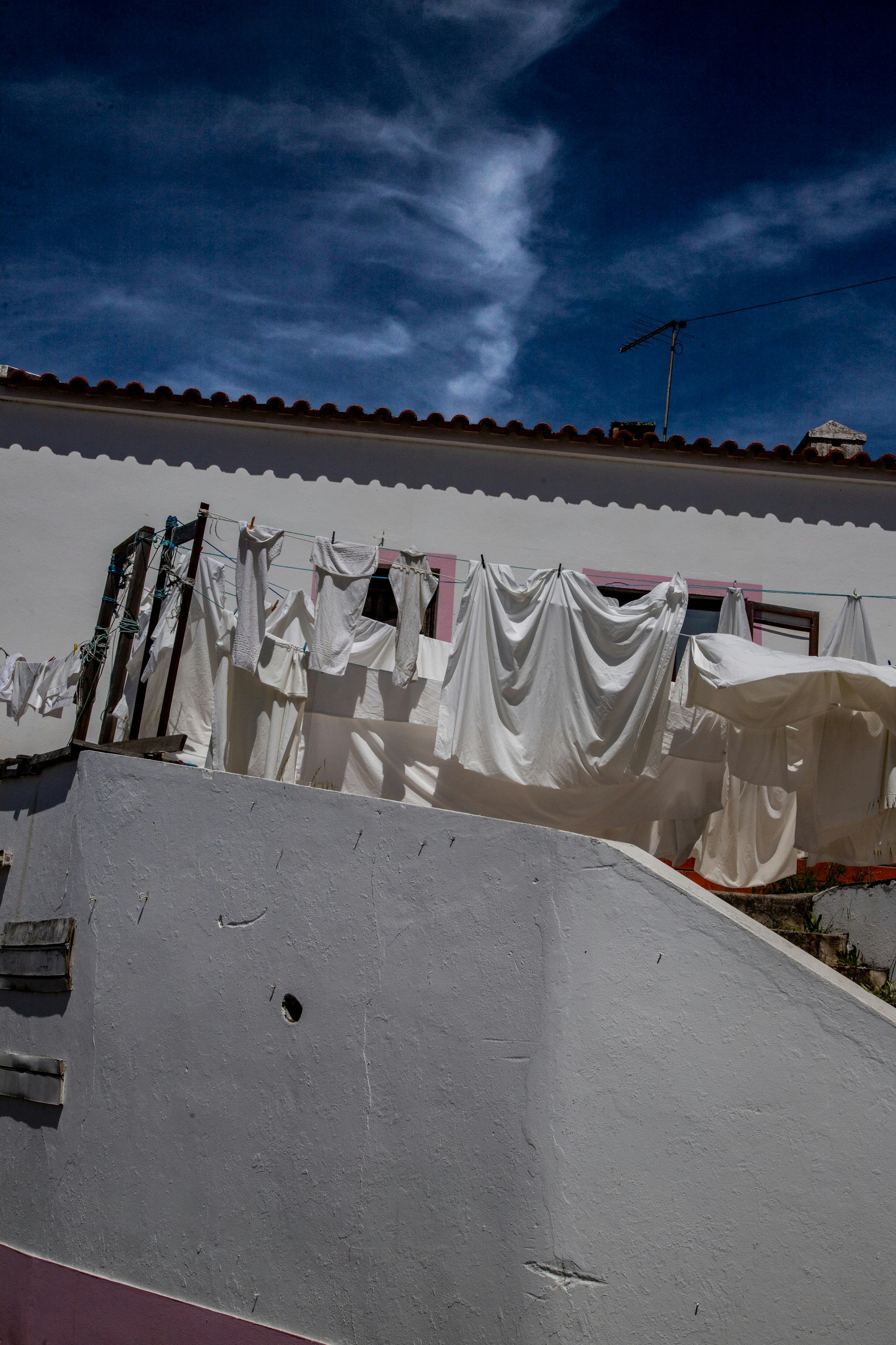 Laundry Lines Under a Blue Sky Over a White Terrace