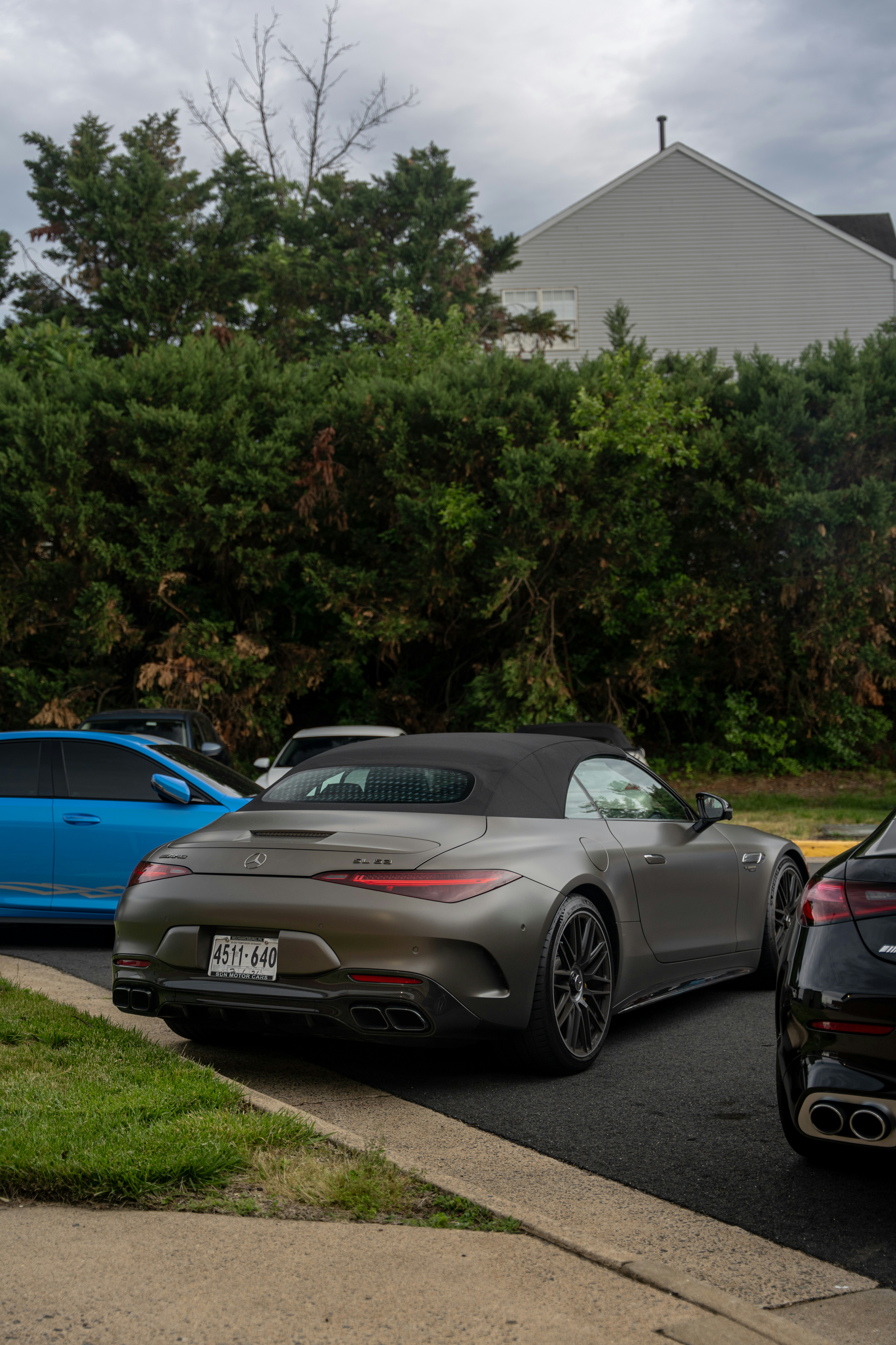Midday Driveway: A Row of Sleek Convertibles by the Hedge