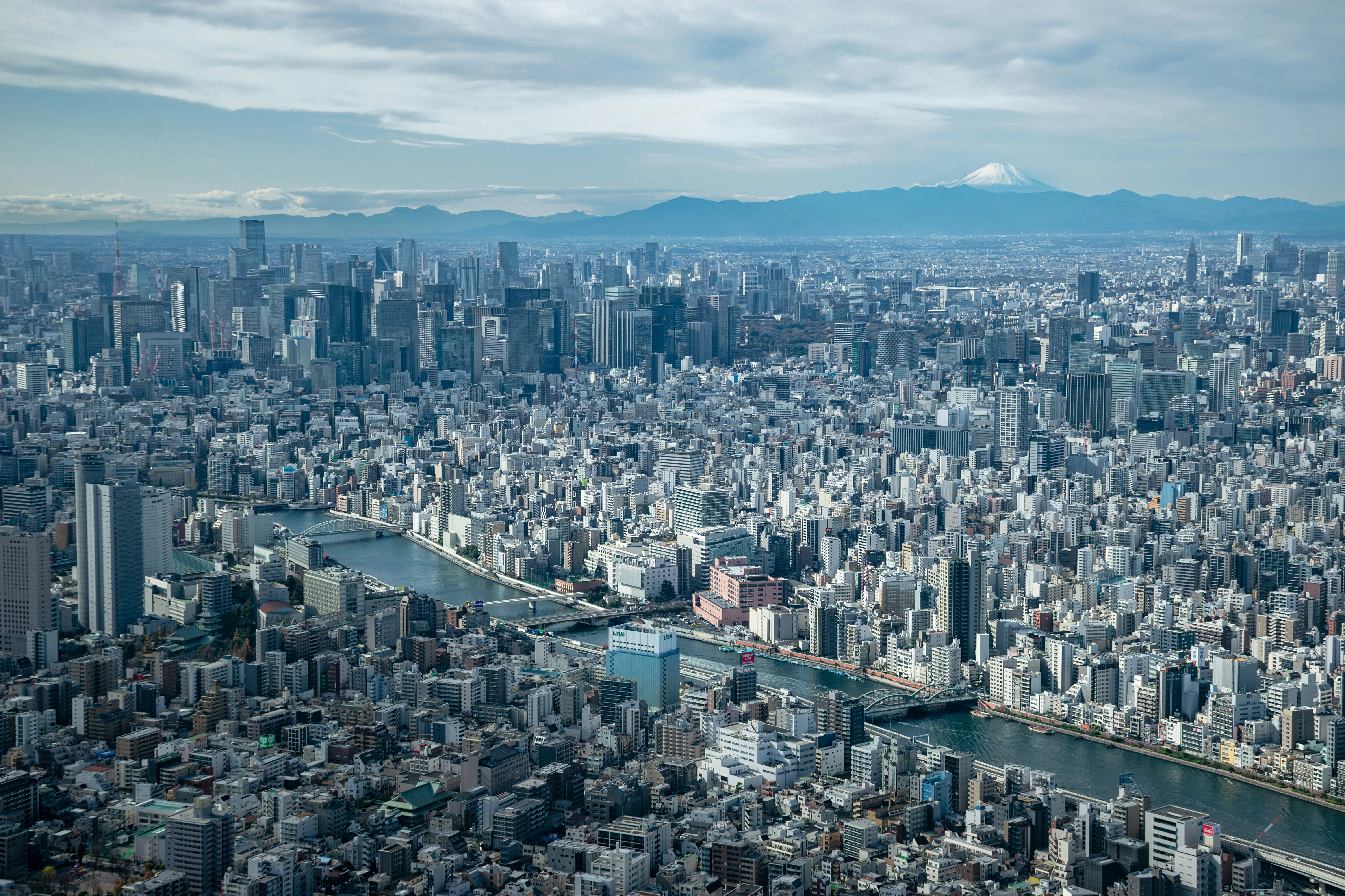 Aerial Tapestry: City Grid Weaving Toward distant Volcano