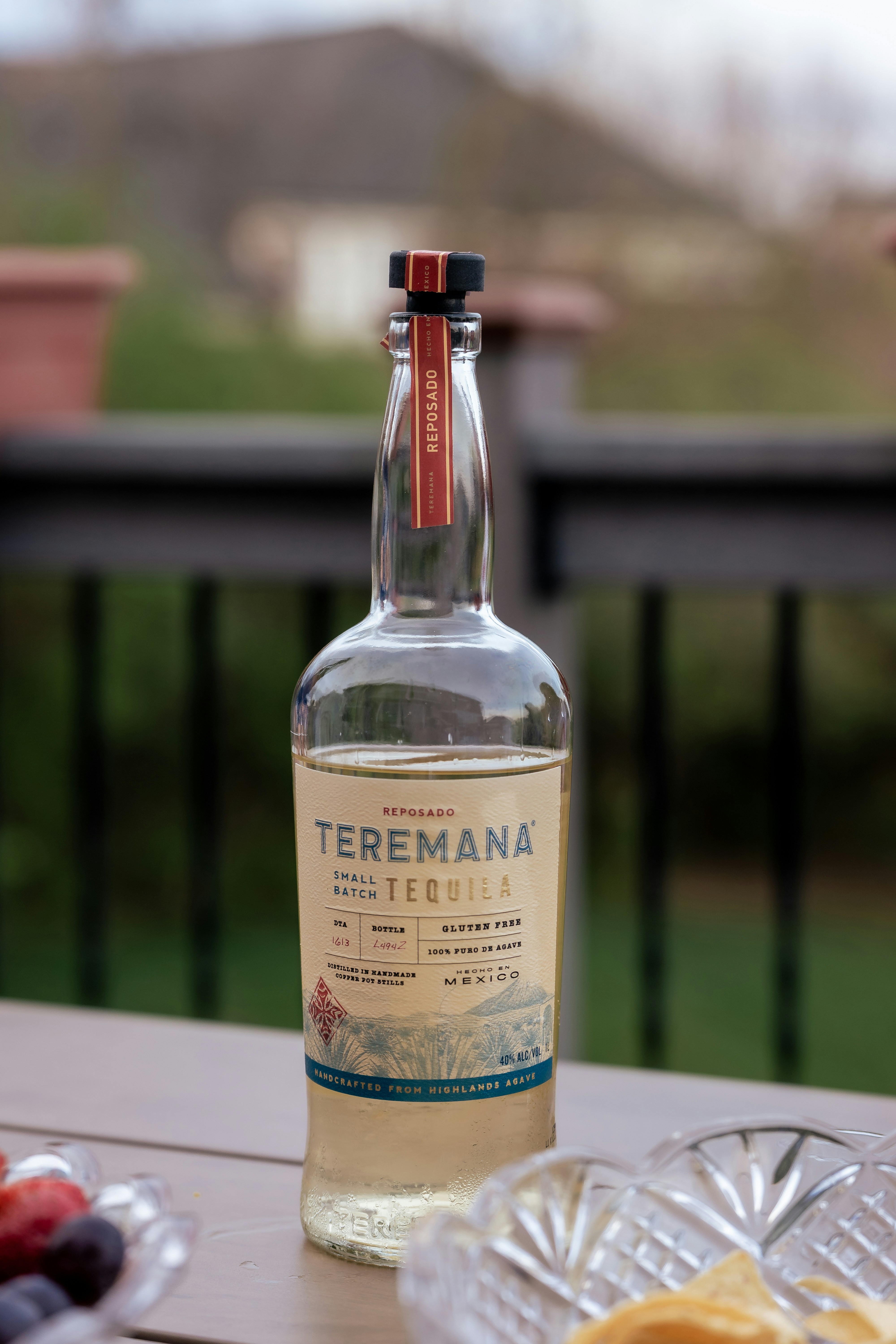 Tequila on the Terrace: Teardrop Bottle Centered Against a Quiet Backyard