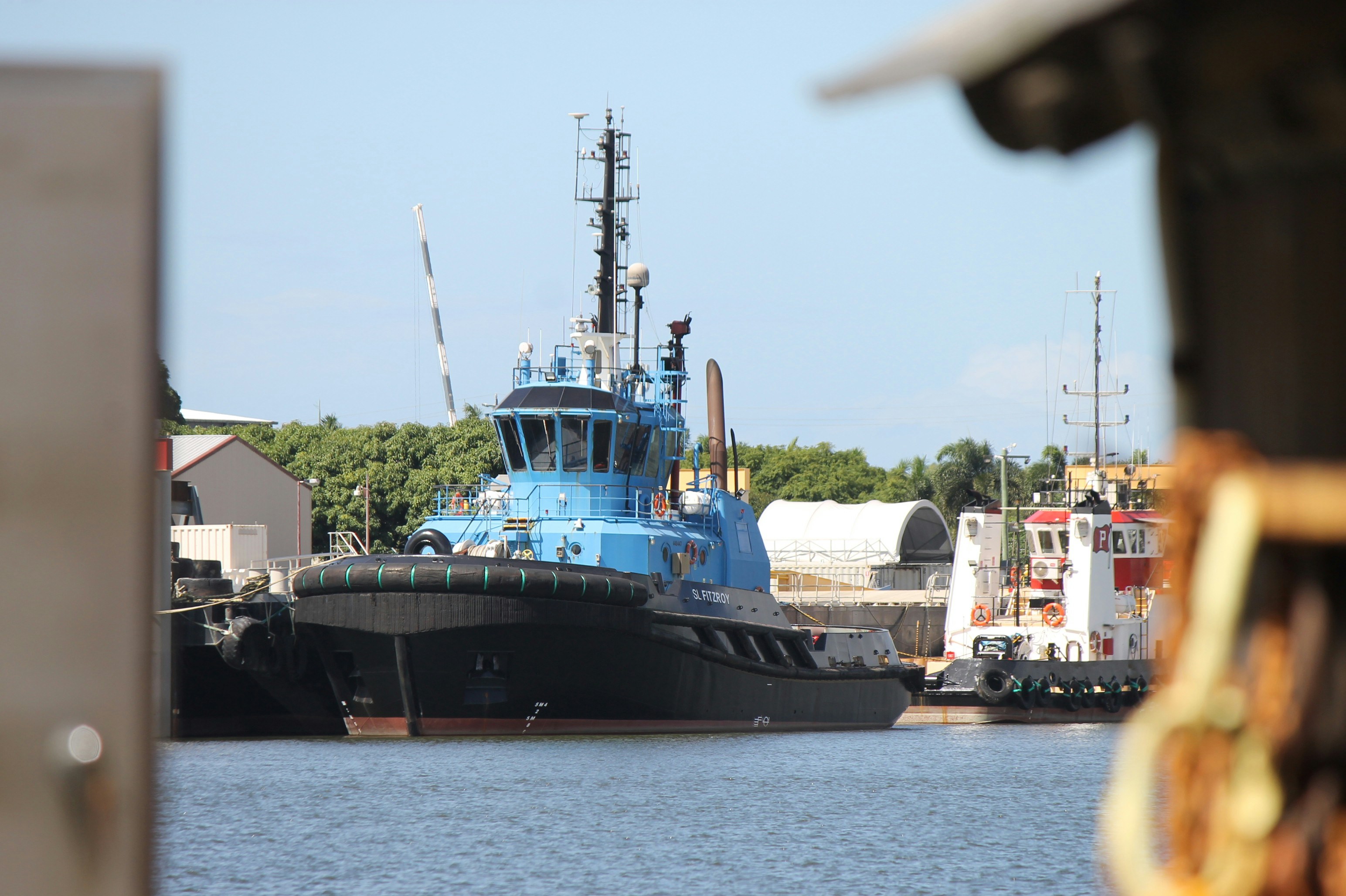 Blue Tug at the Dock: A Maritime Morning across the Still Water