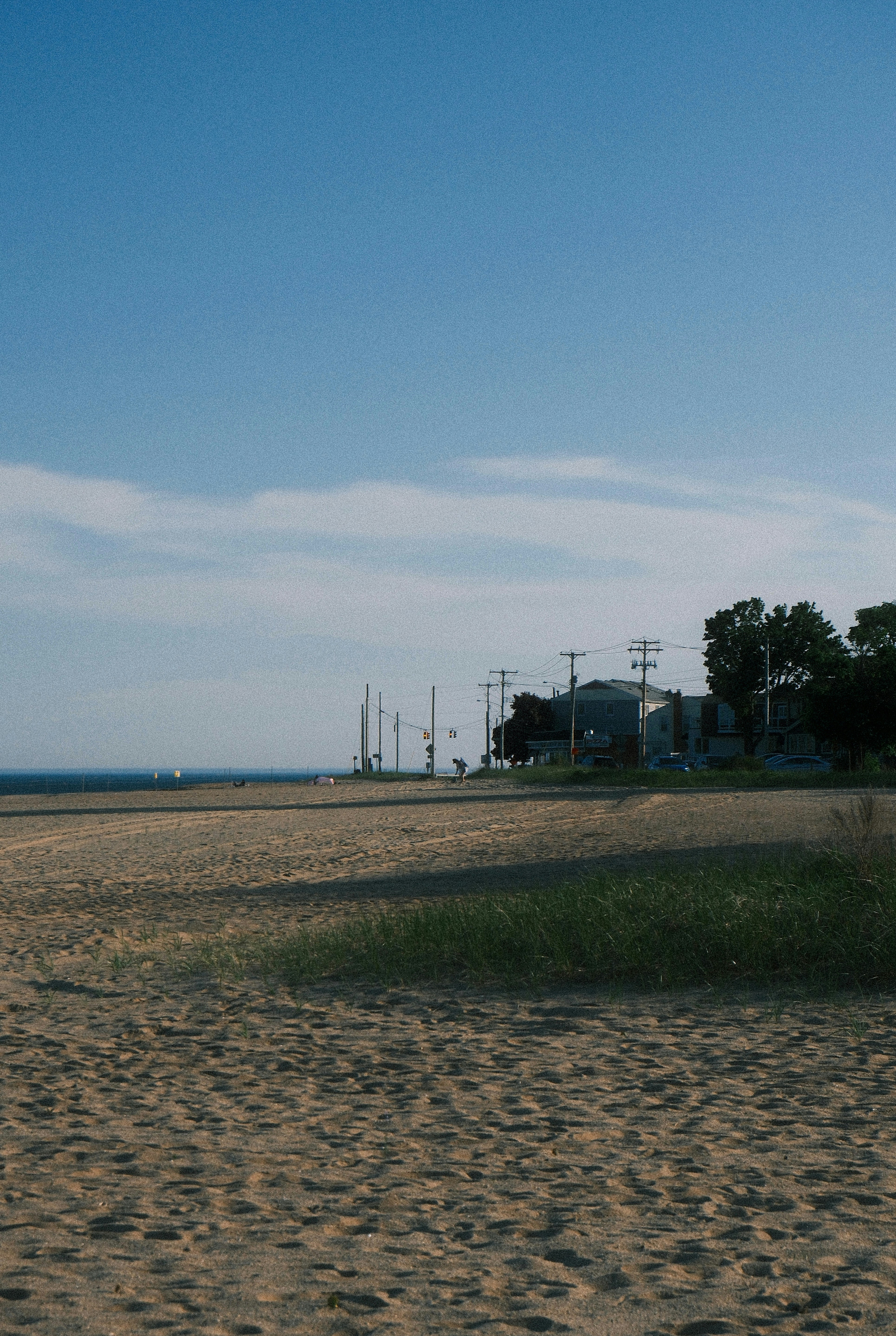 Quiet Coastal Street: Sand, Sea, and Suburban Silence