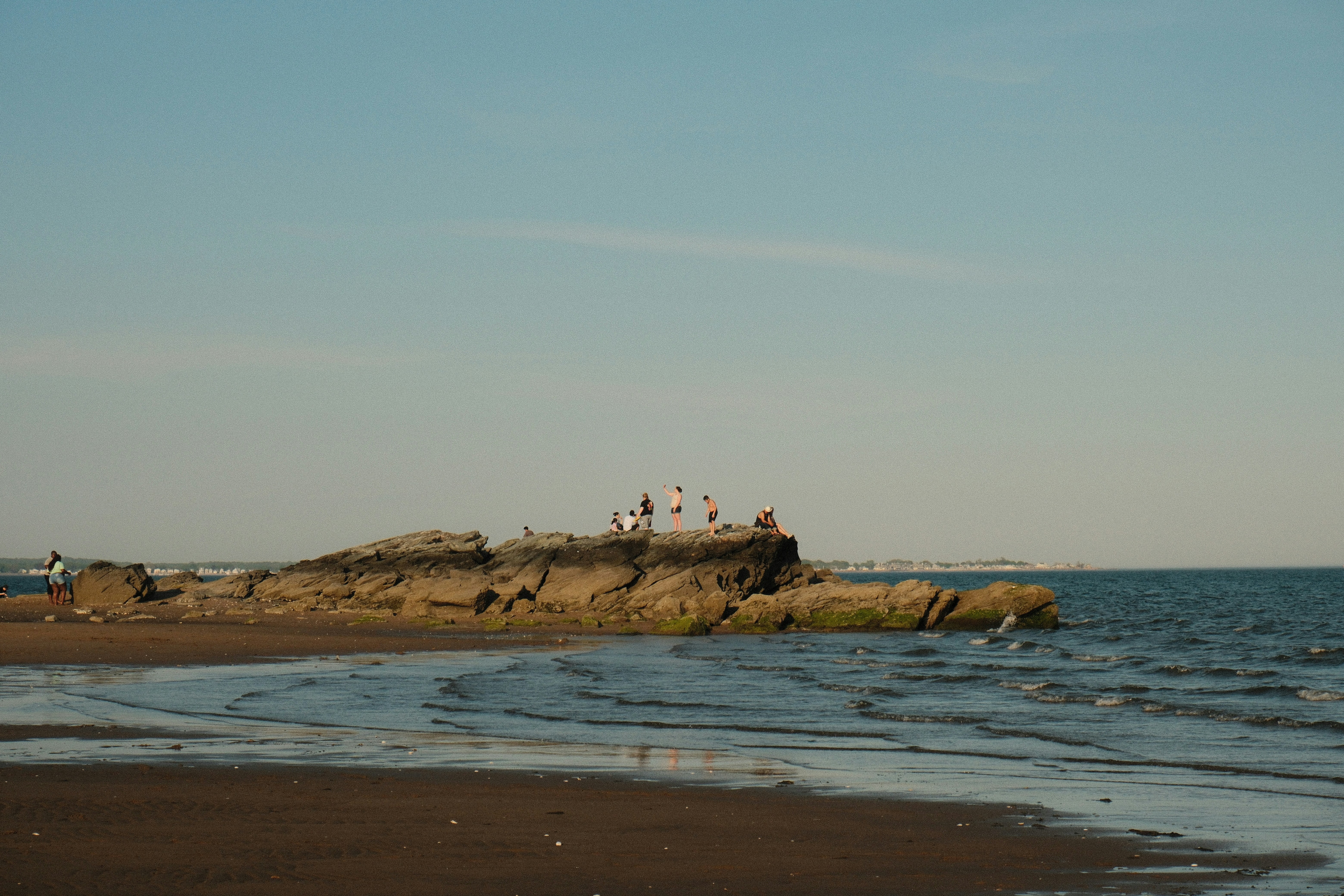 People at the rocky outcrop on a tranquil beach