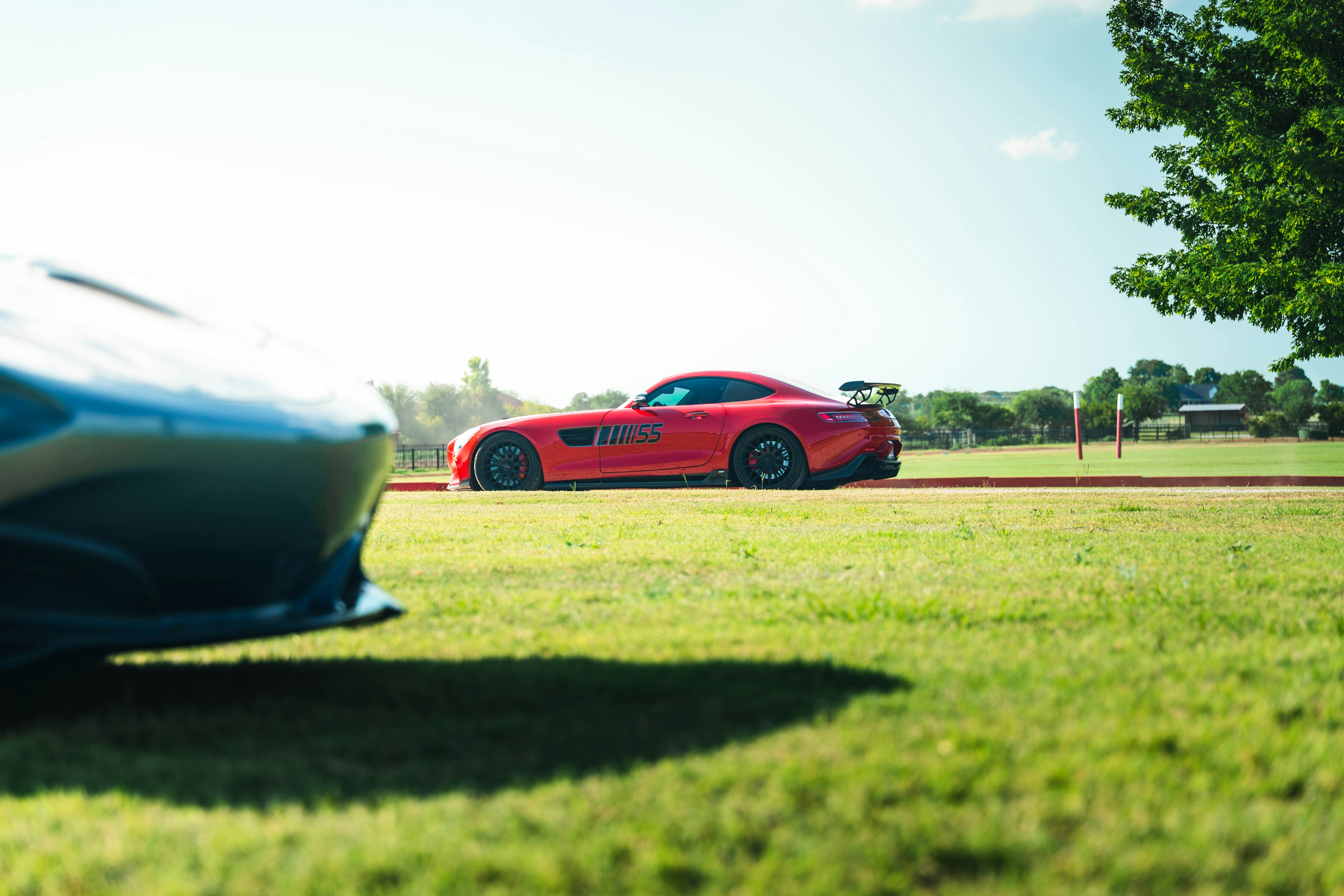 Red Ultramarine: A Red Ferrari-Like Coupe on a Sunlit Track Ridge