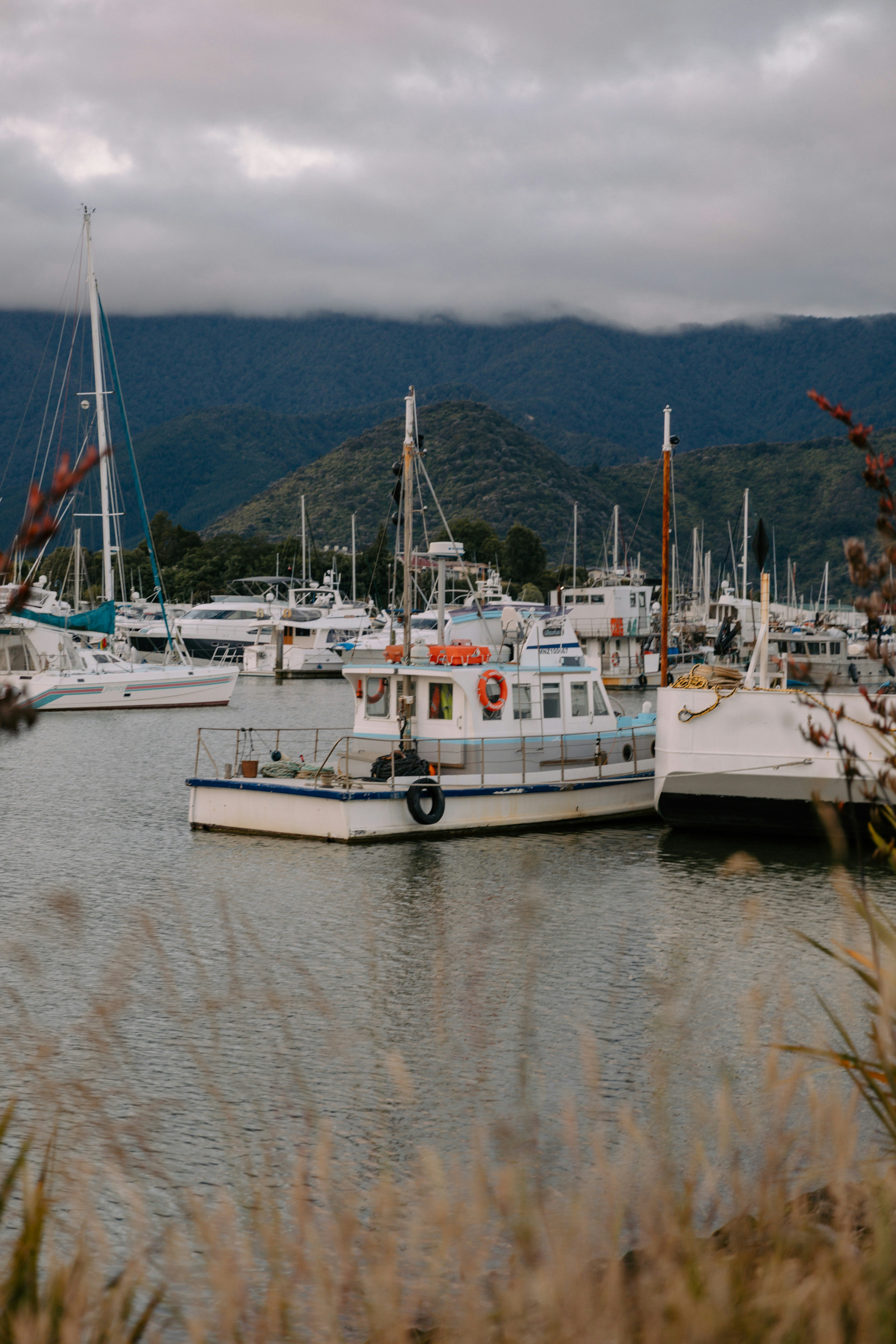  harbor silhouettes: boats at rest beneath a clouded ridge