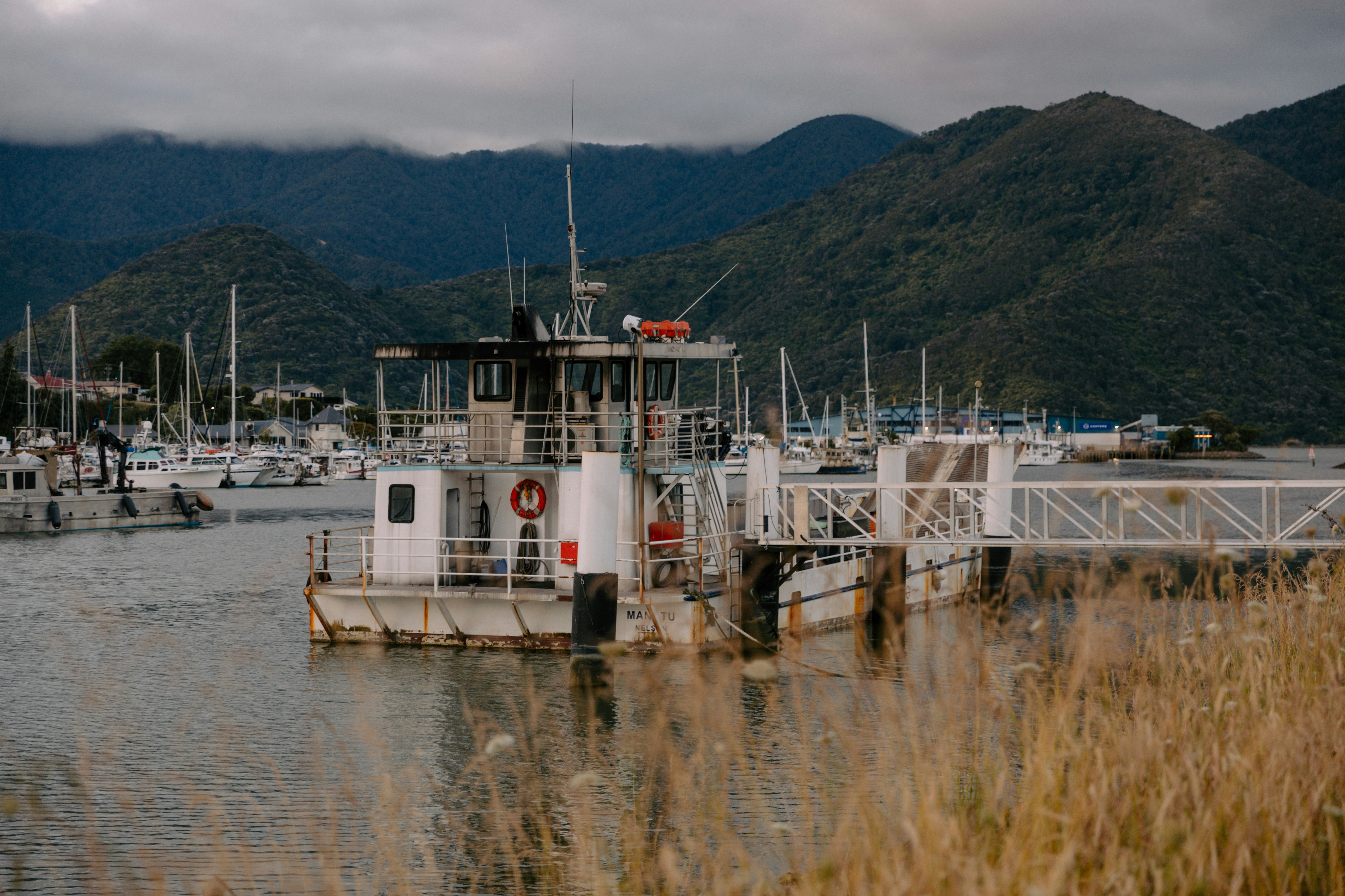 Harbor Pier at Dusk: Boats Resting as Mountains Rise