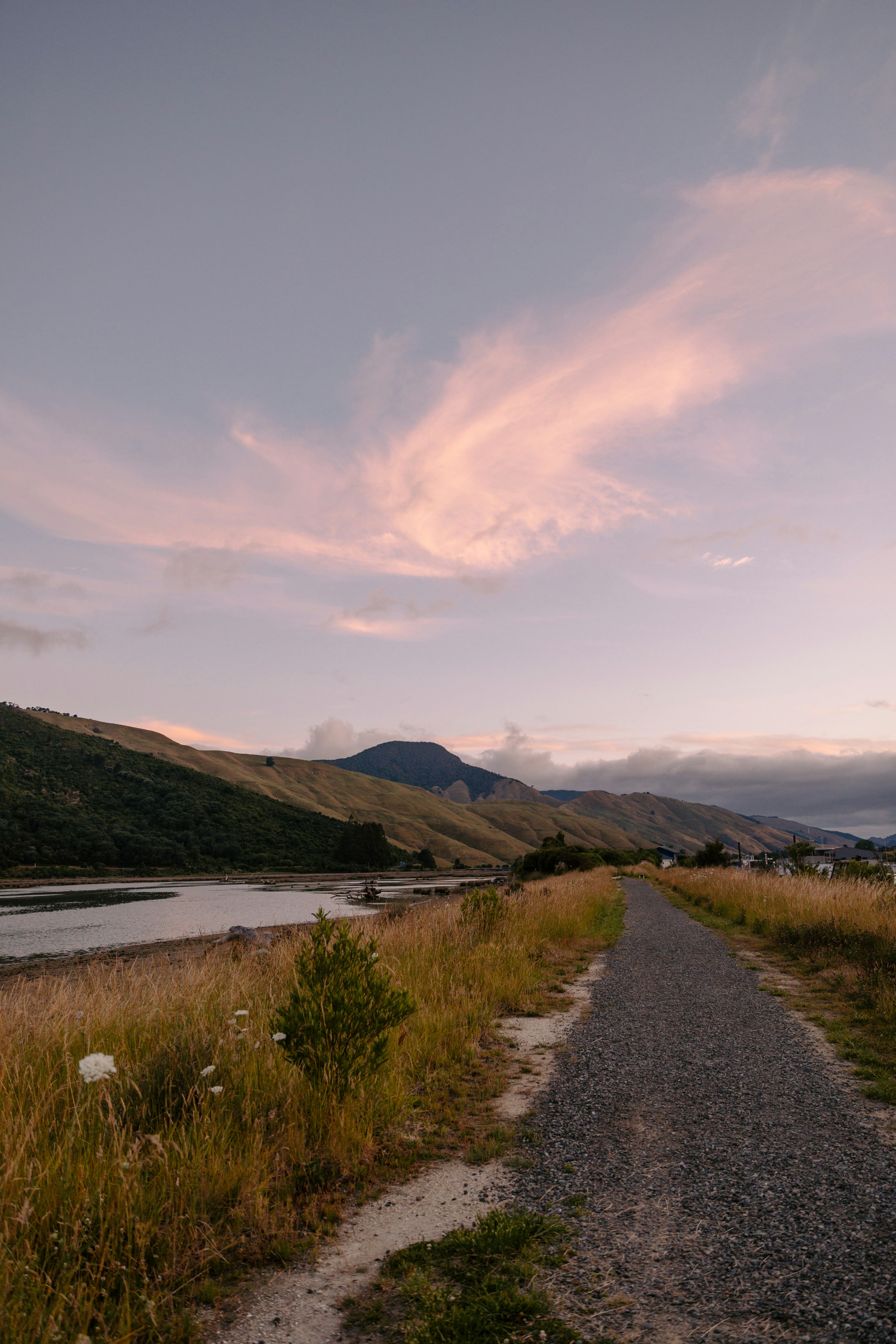 Gravel Path toward the Valley, with Silhouetted Hills at Dusk