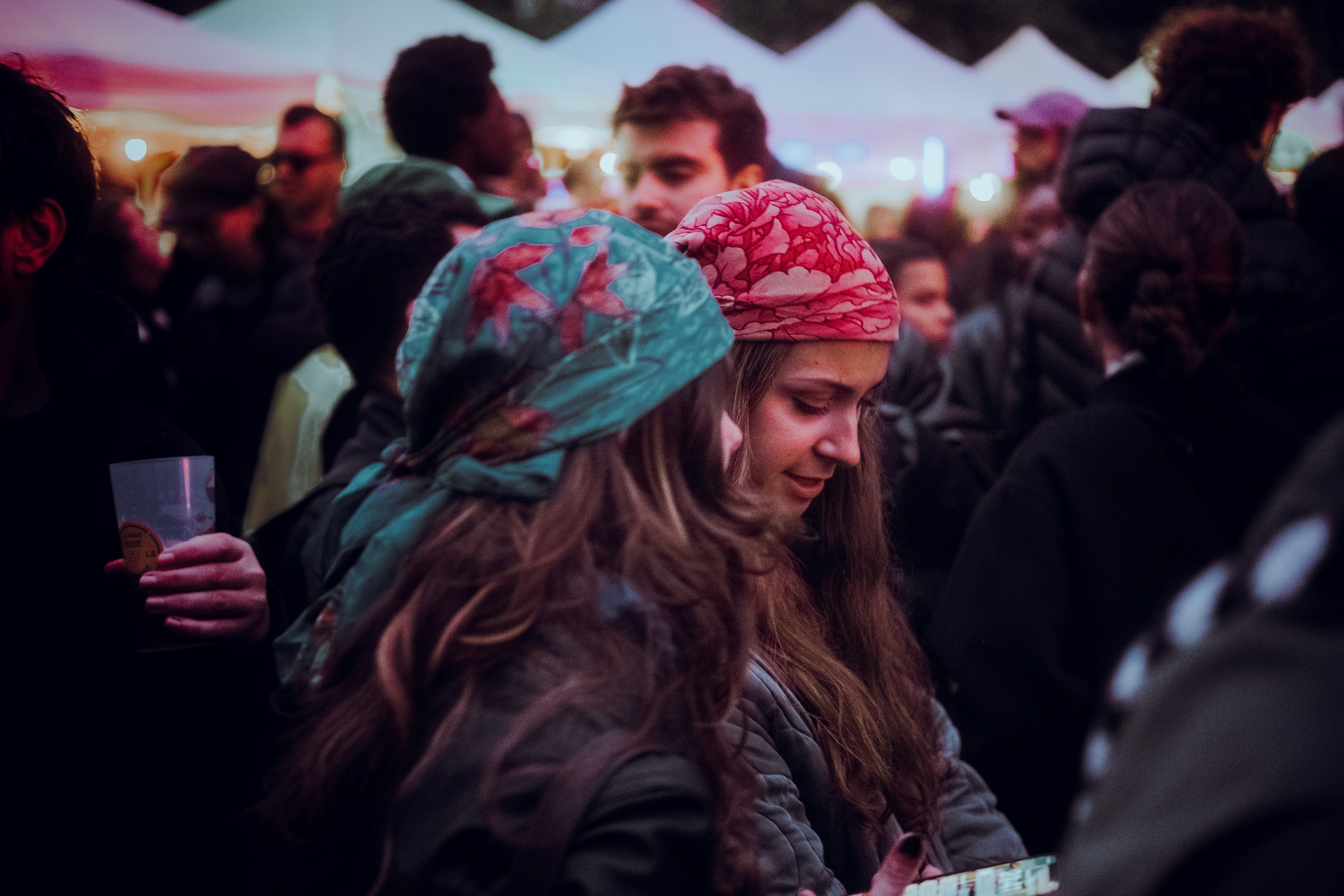 Bandana-clad conversation in a lively twilight crowd