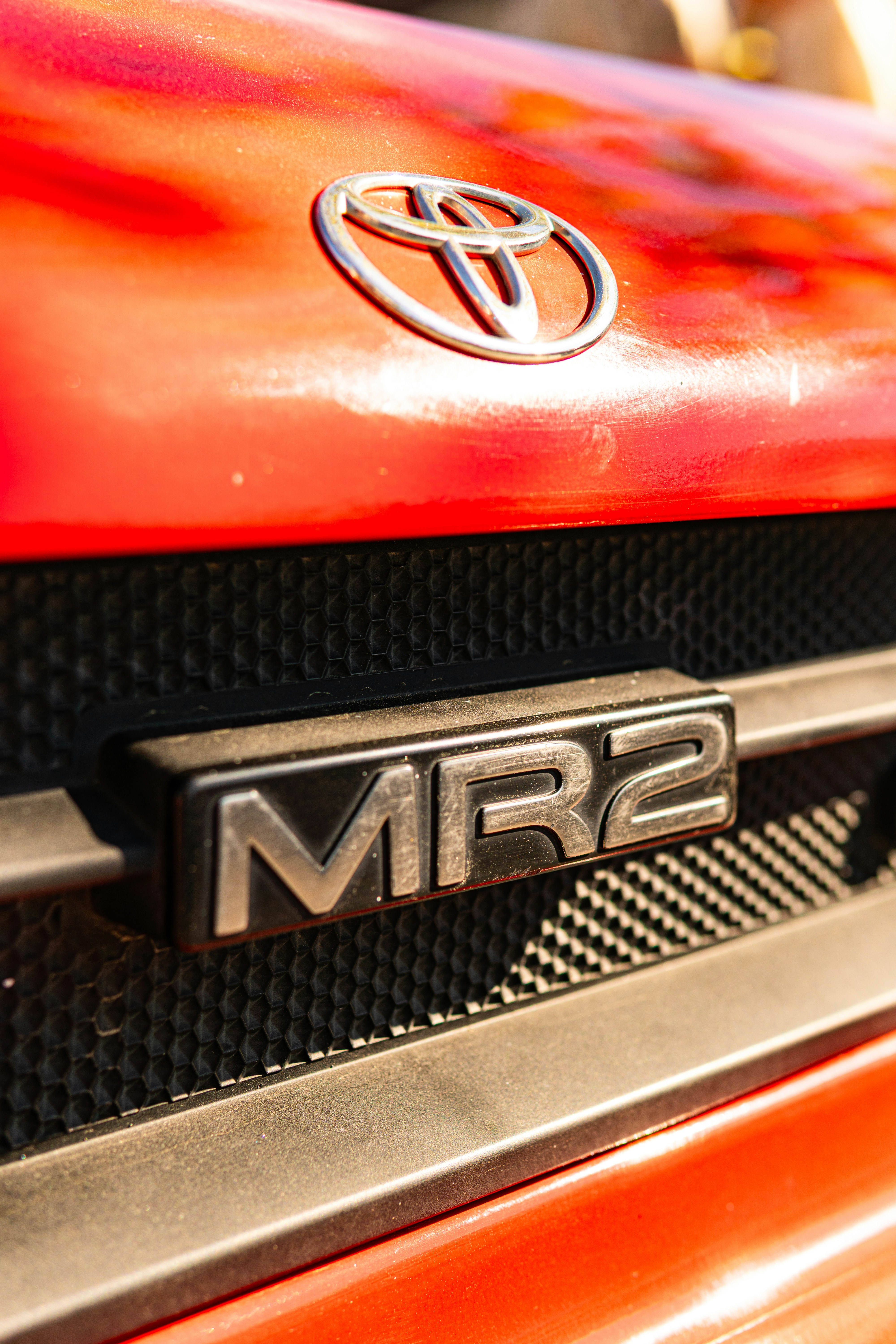 Close-up of the MR2 Emblem Gripping a Bold Red Front Grille