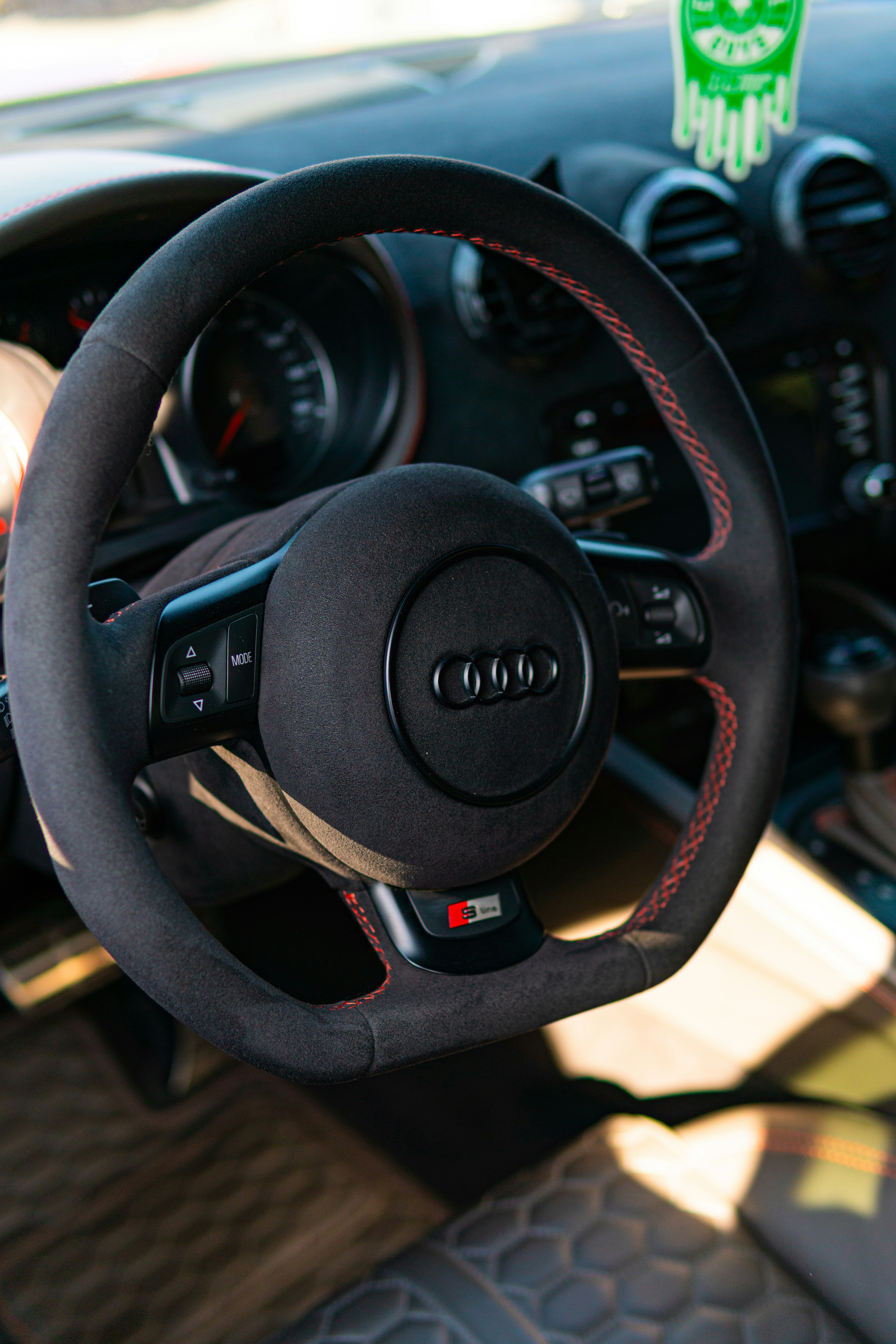 Steering Wheel Studio: A close-up of the Audi cockpit with red-stitching