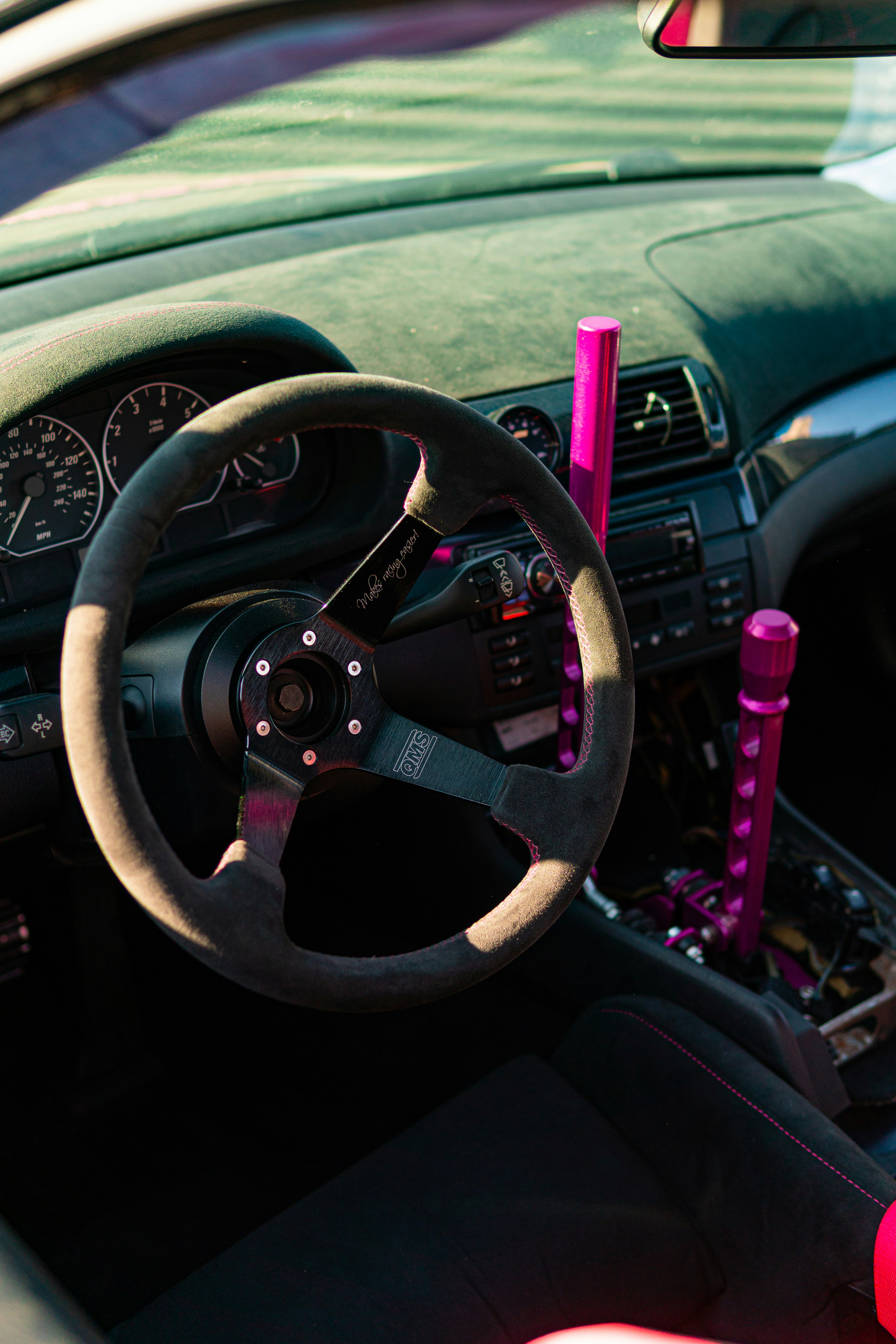 Pink-tinted drift: a compact cockpit with a racing steering wheel