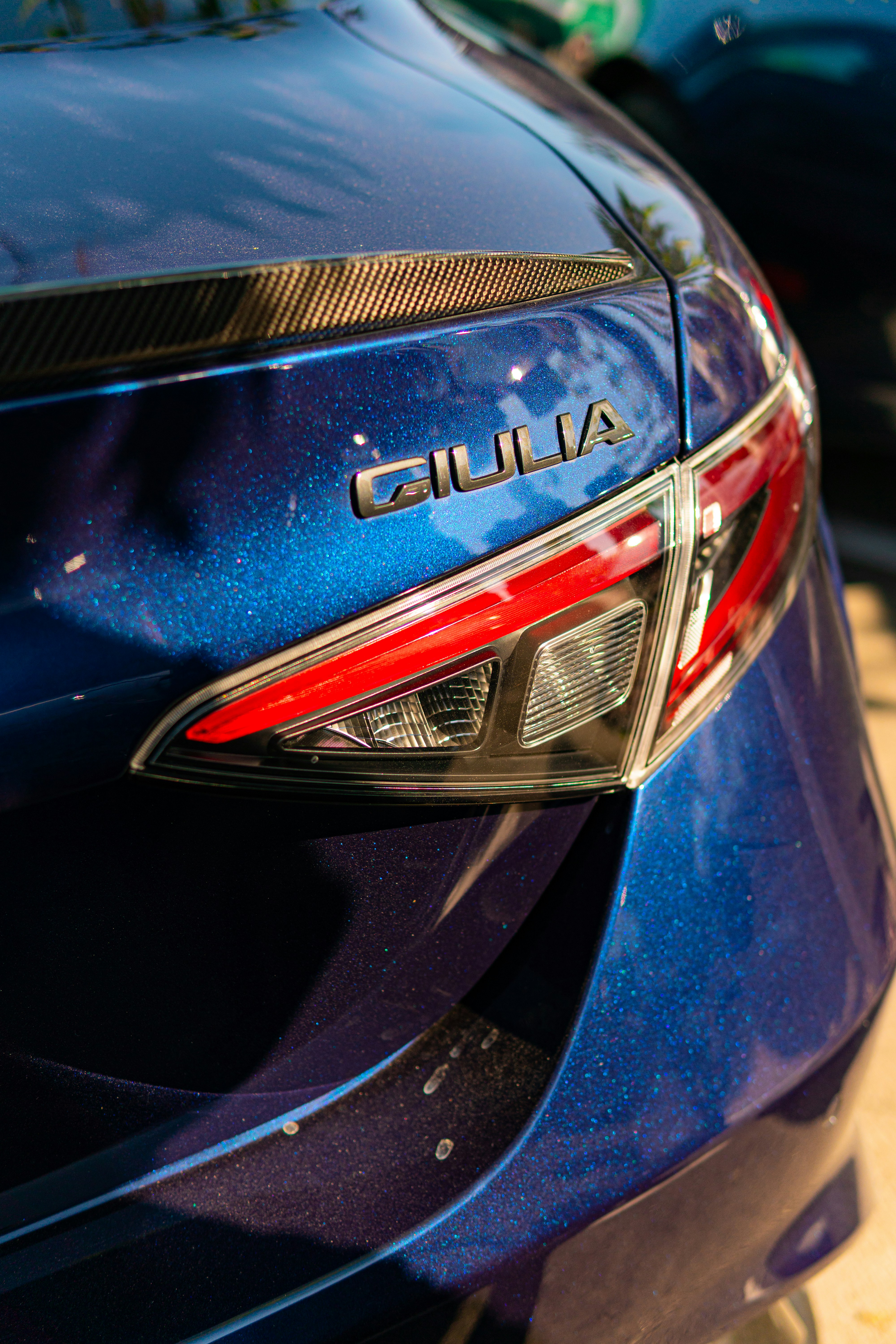 Blue Giulia Behind the Wheel: a close-up of metallic contour and taillight gleam