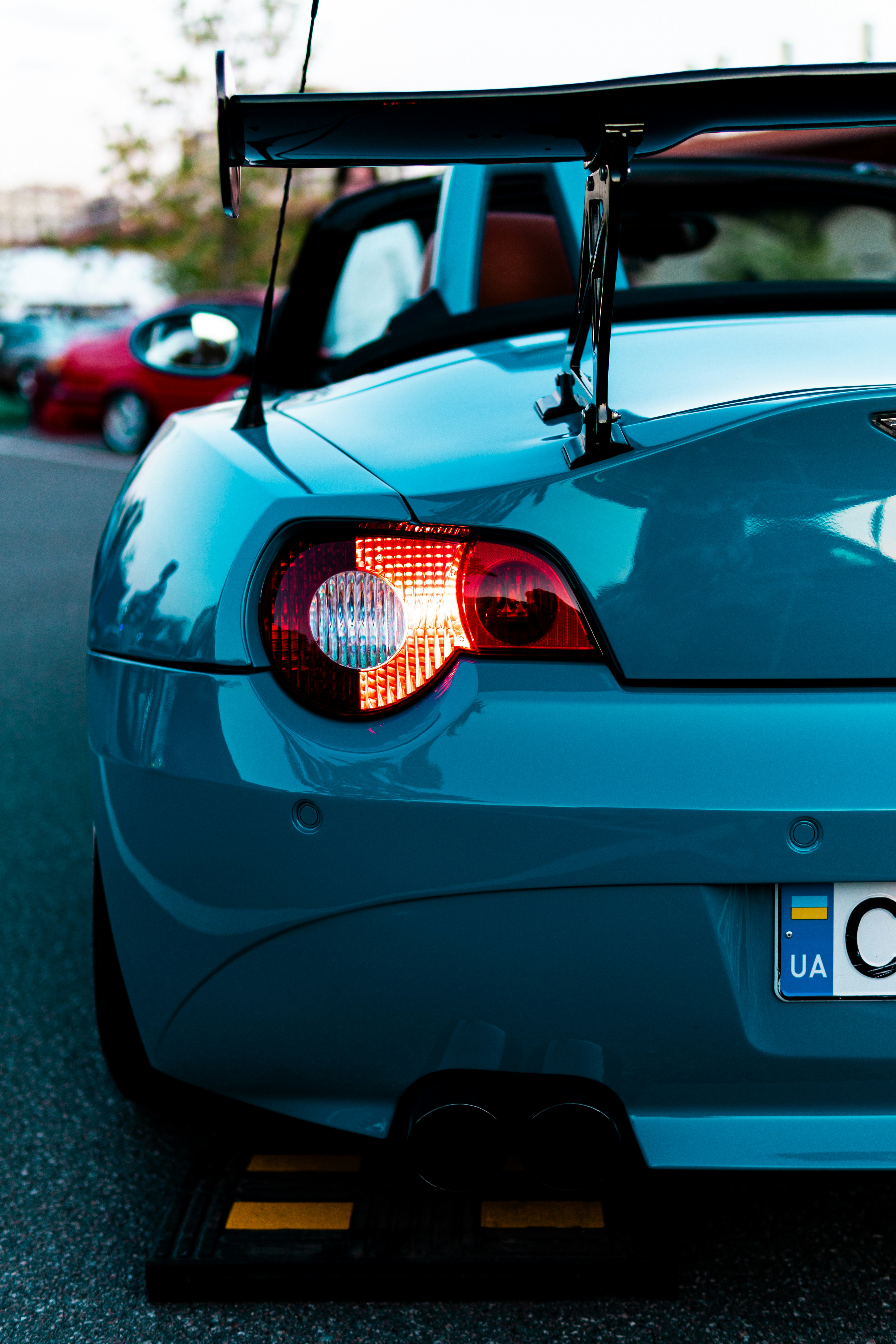 Blue Drifter: Rear end of a tuned sports car under edge-lit evening light