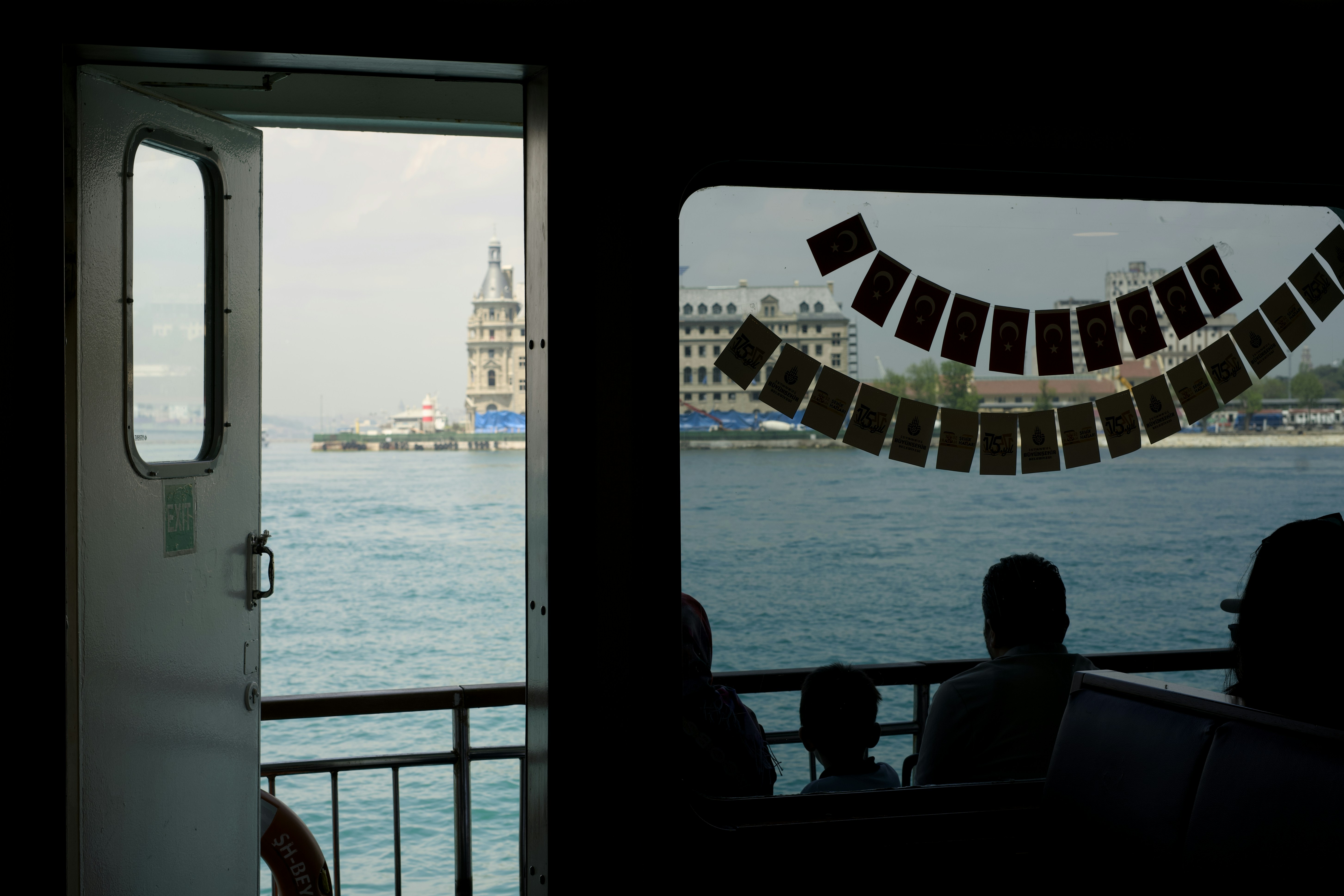 From the Ferry Window: A Glimpse of the City Through Shadowed Glass