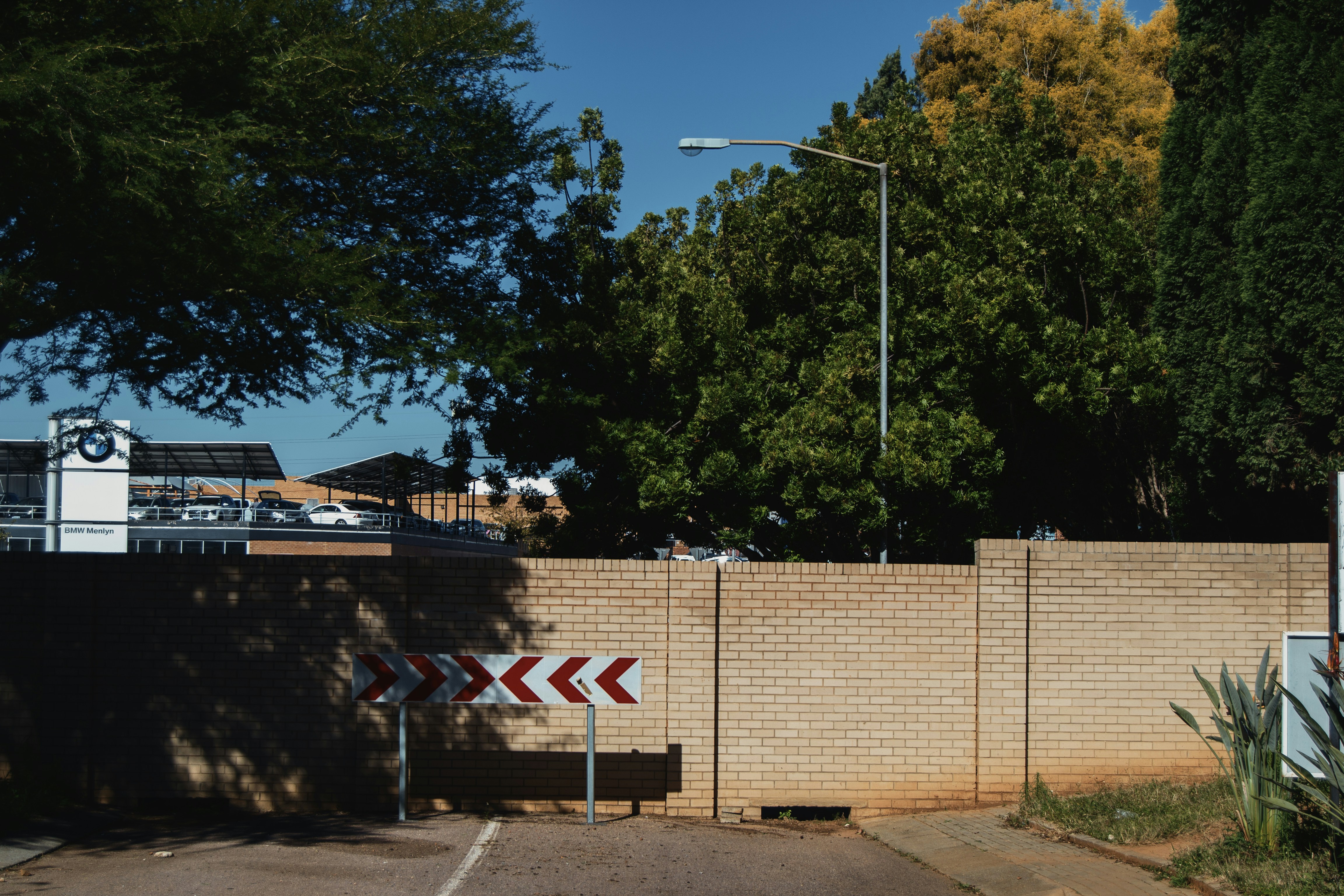 Brick Wall Barrier Under Blue Sky with Arrow Signage